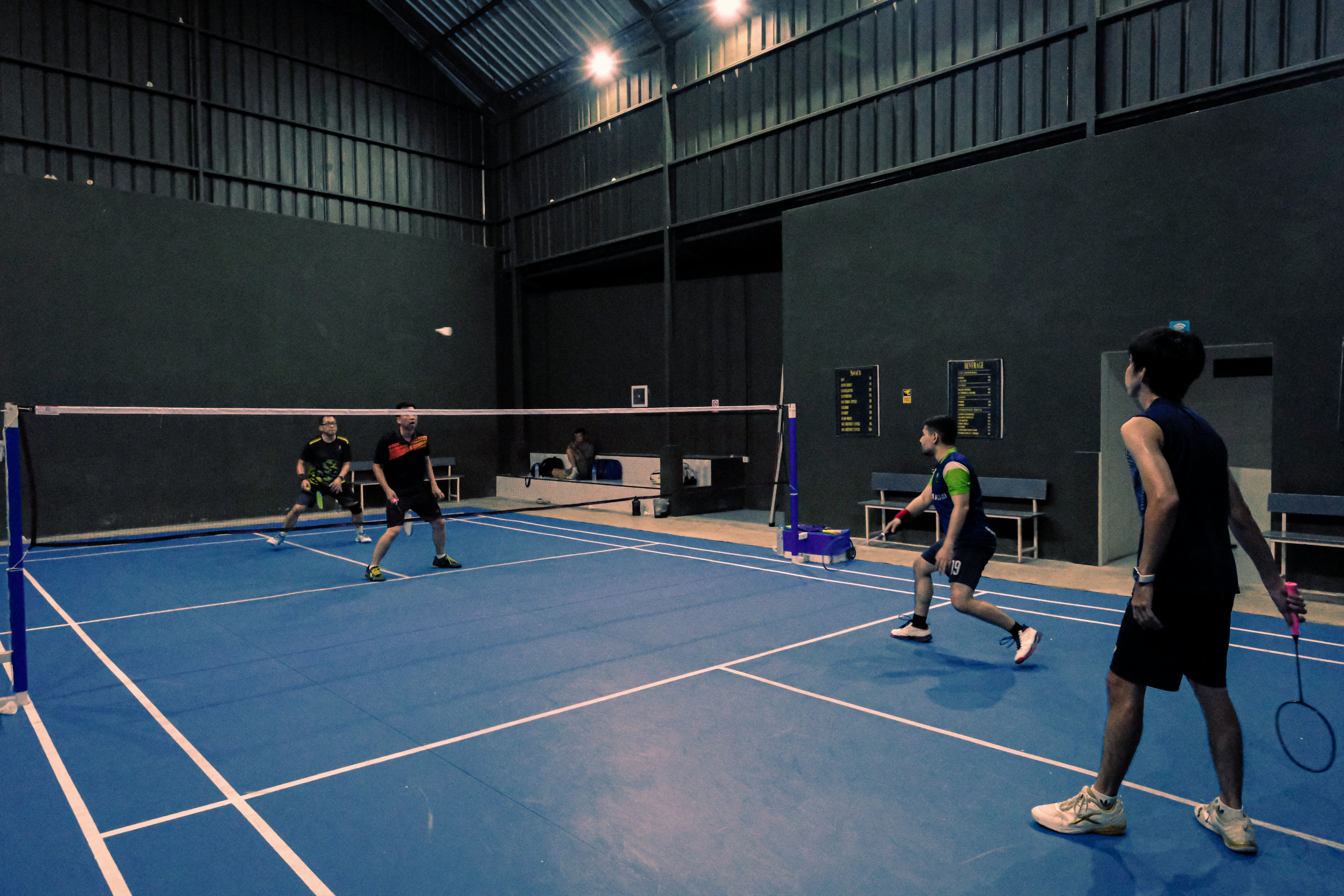 Mid‑Court Rally: Four Players Converge Under Gymnasium Lights