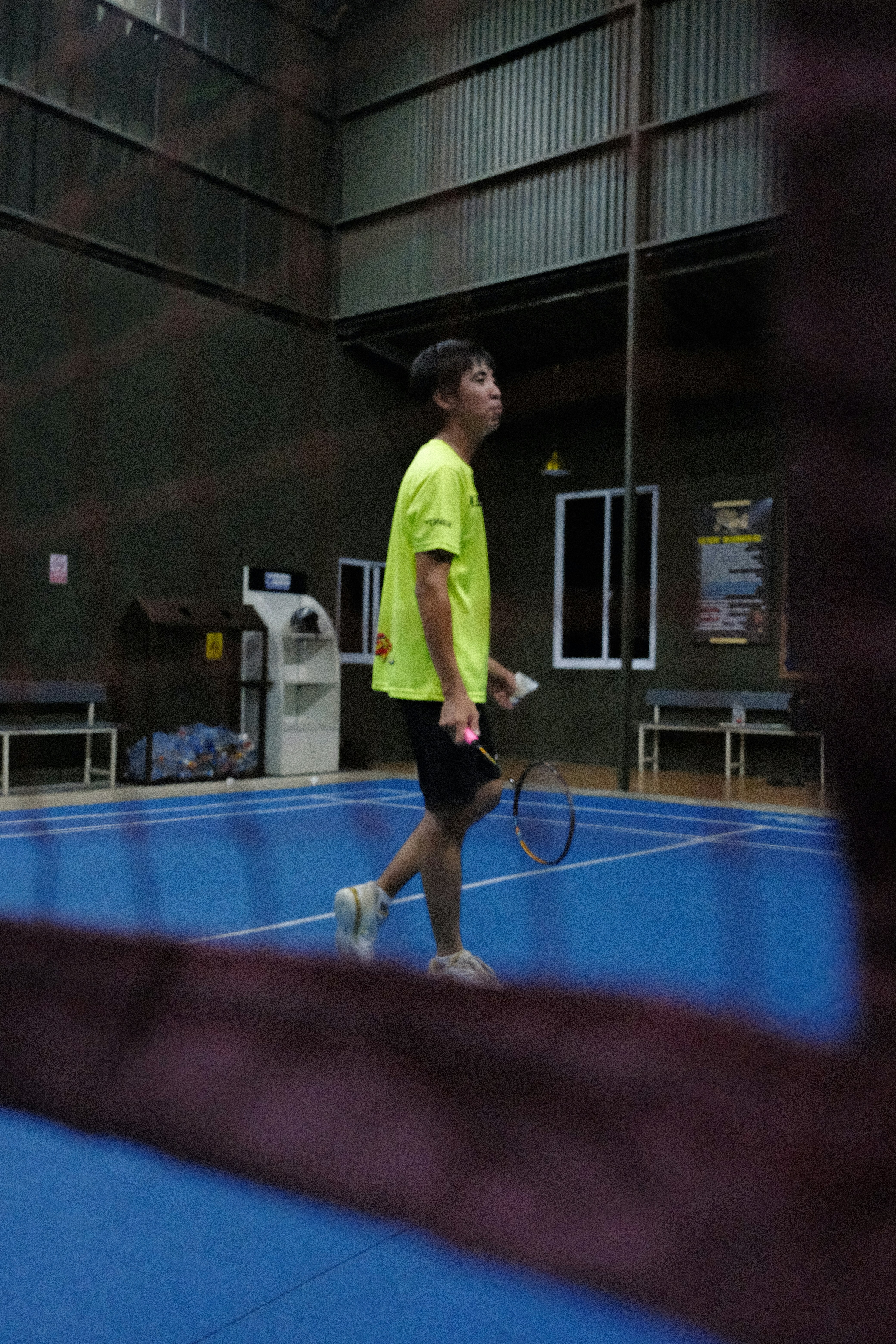 Neon-green-tee Player Pauses Mid-Court in an Indoor Gym