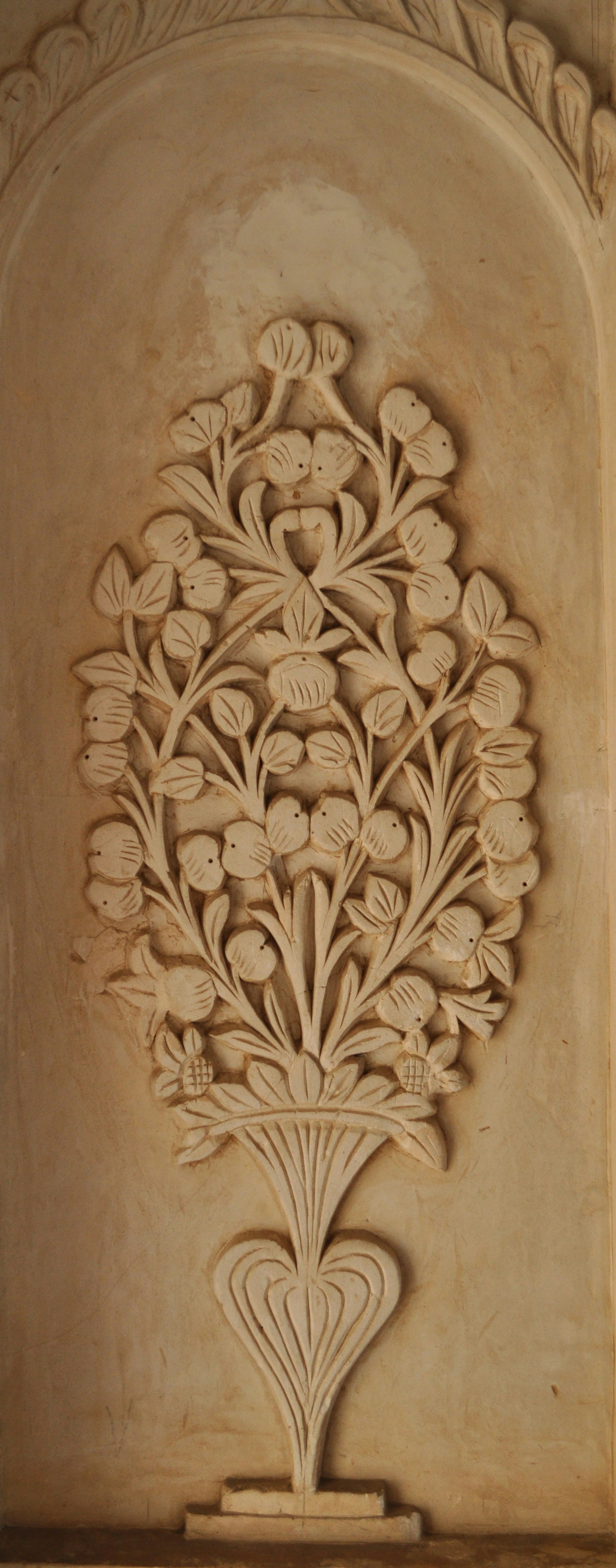 Intricate stone relief: a stylized floral bouquet carved in warm sandstone