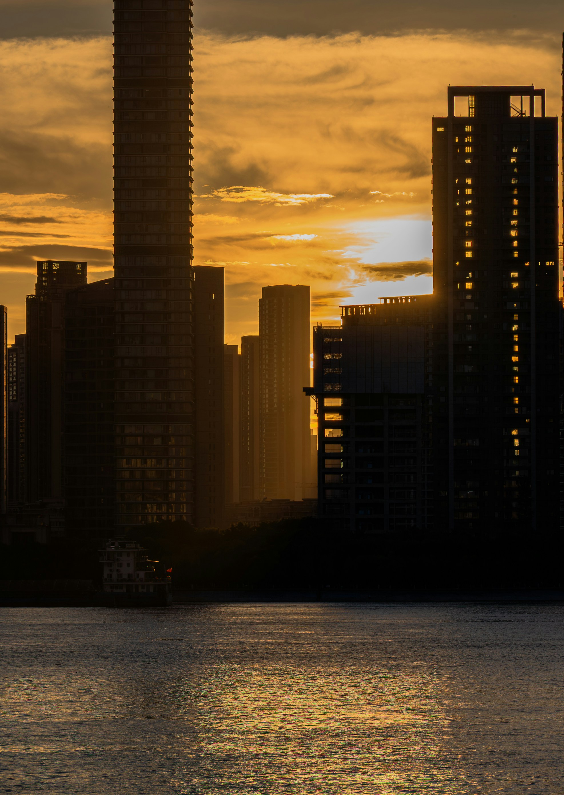 Sunset Over Tall Glass: City Silhouette on the River