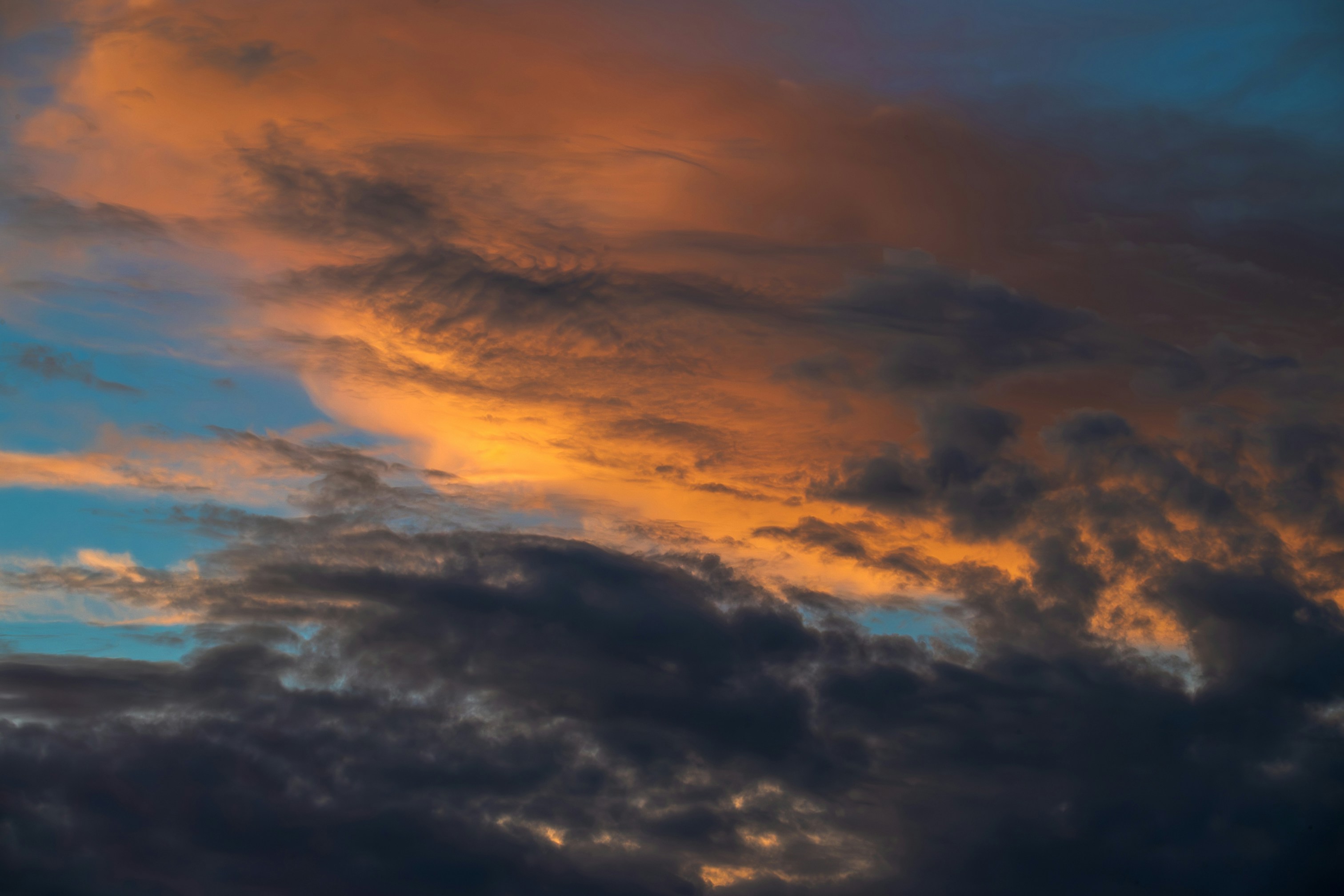 Sunset Inferno: Ember Clouds Over a Quiet Horizon