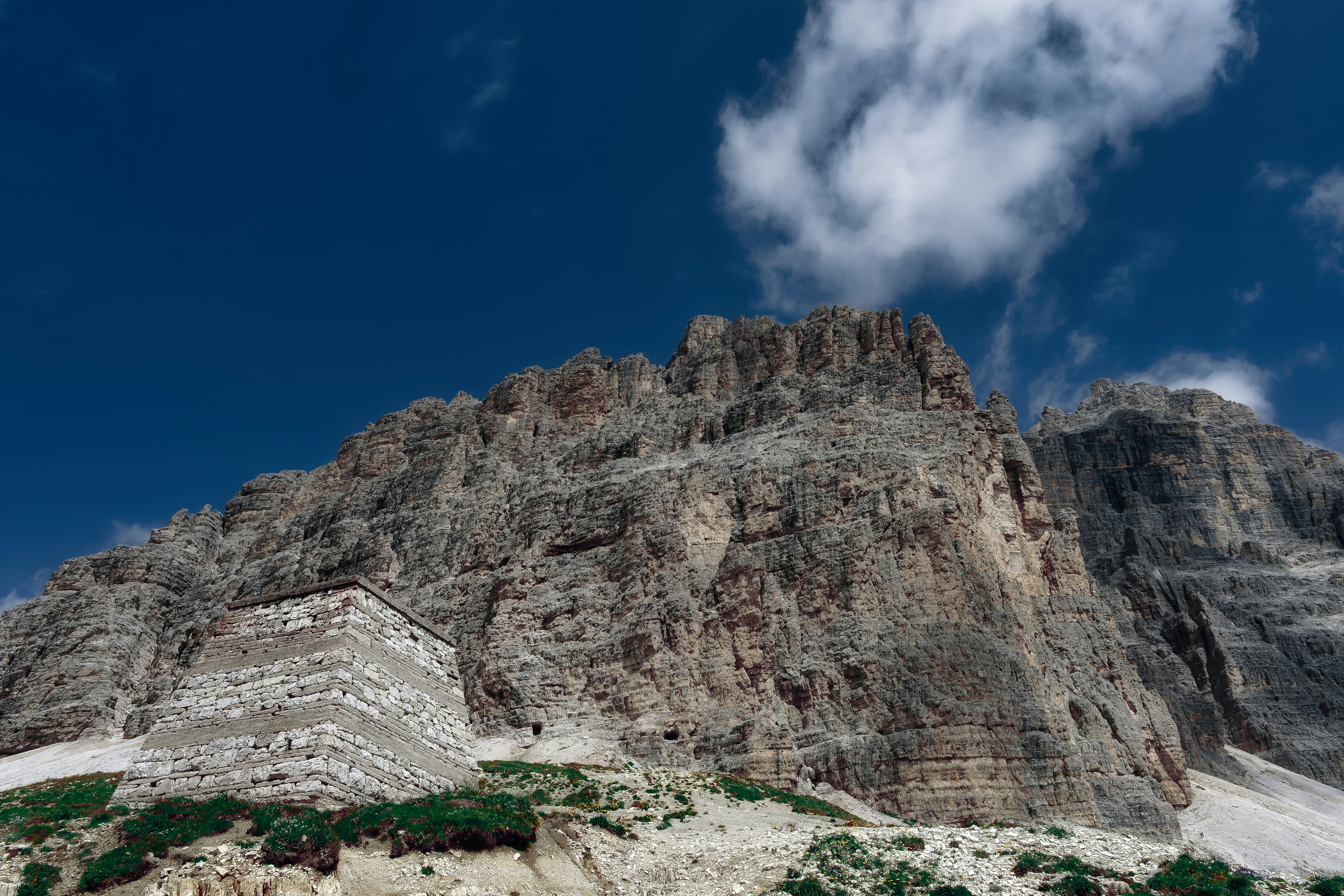 Stone Sentinel: Cliff Face and Terrace Under a Wide Blue Sky