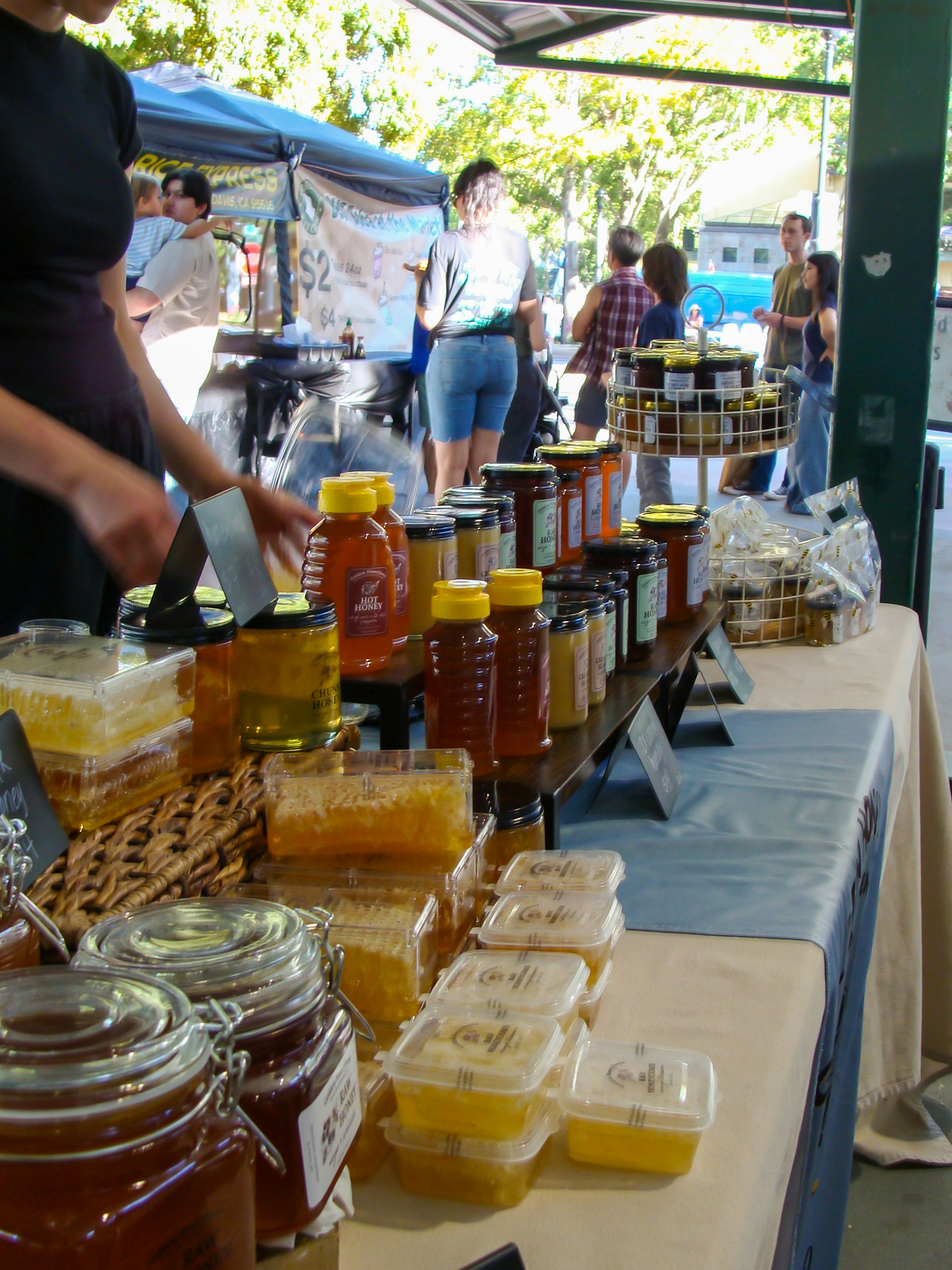 Market Table of Golden Honey: Bottles and Bees in Focus