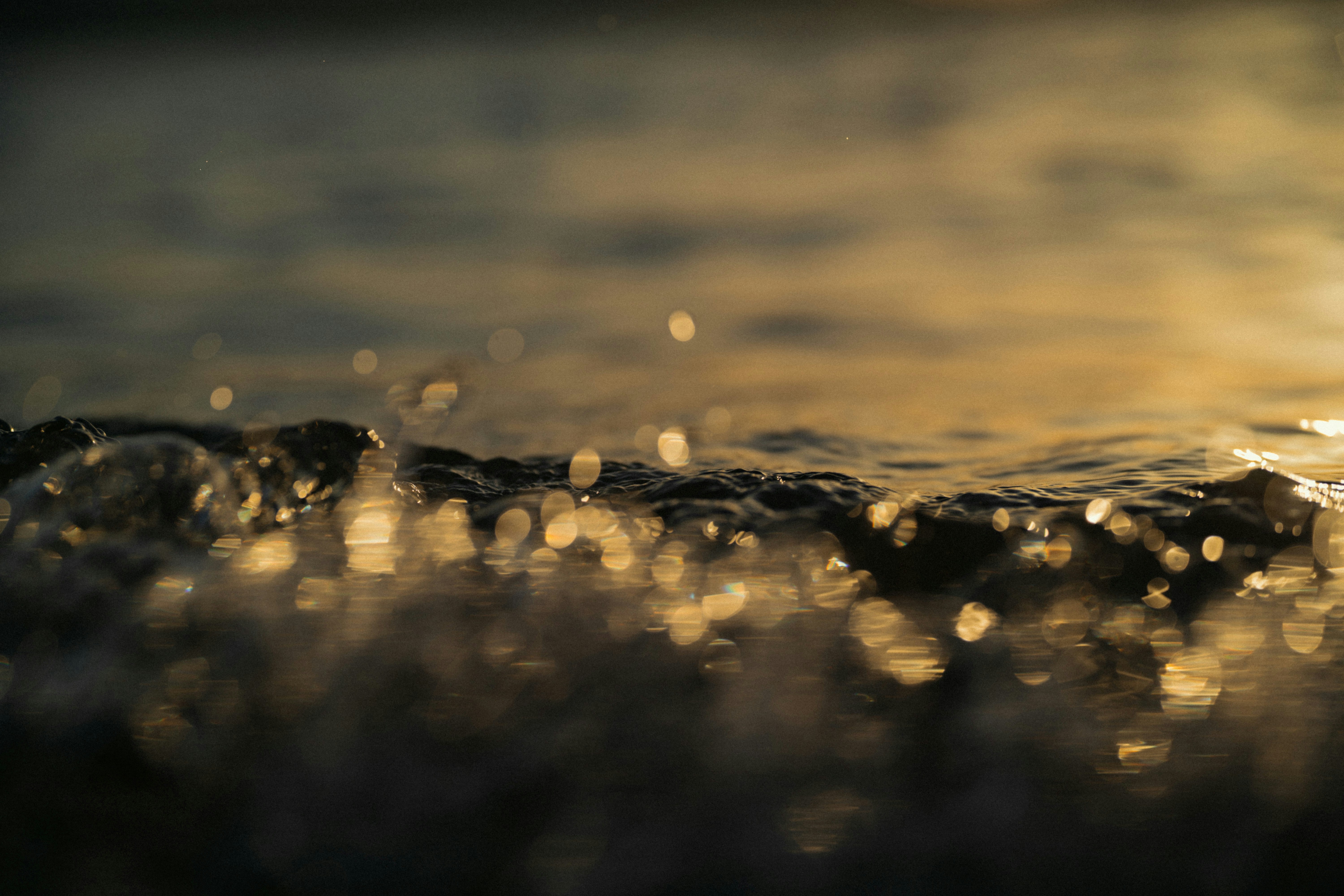 Golden Ripples: Sunlit Droplets Catch the Wave's Edge