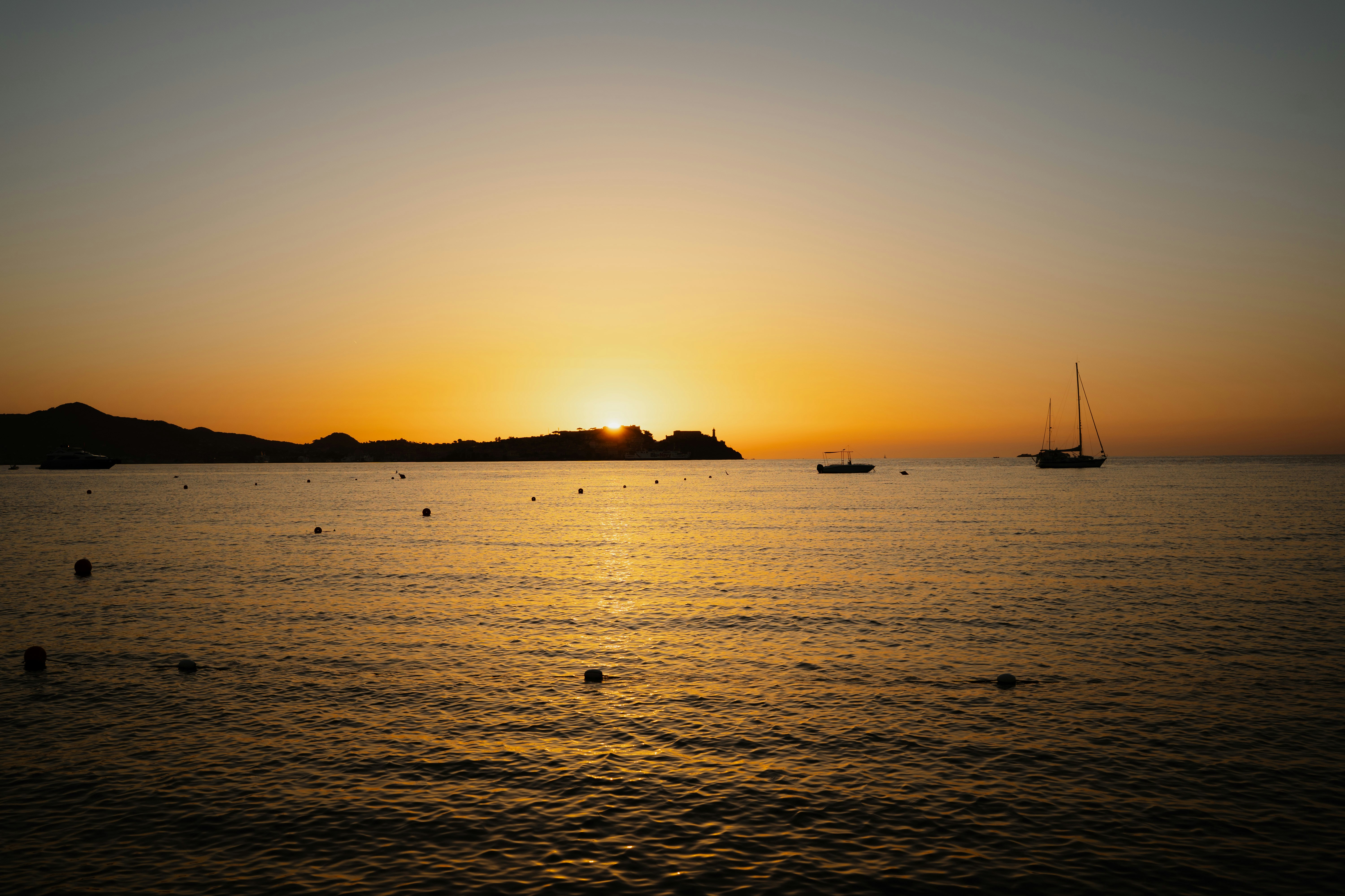 Silhouetted horizon at golden hour over a tranquil bay