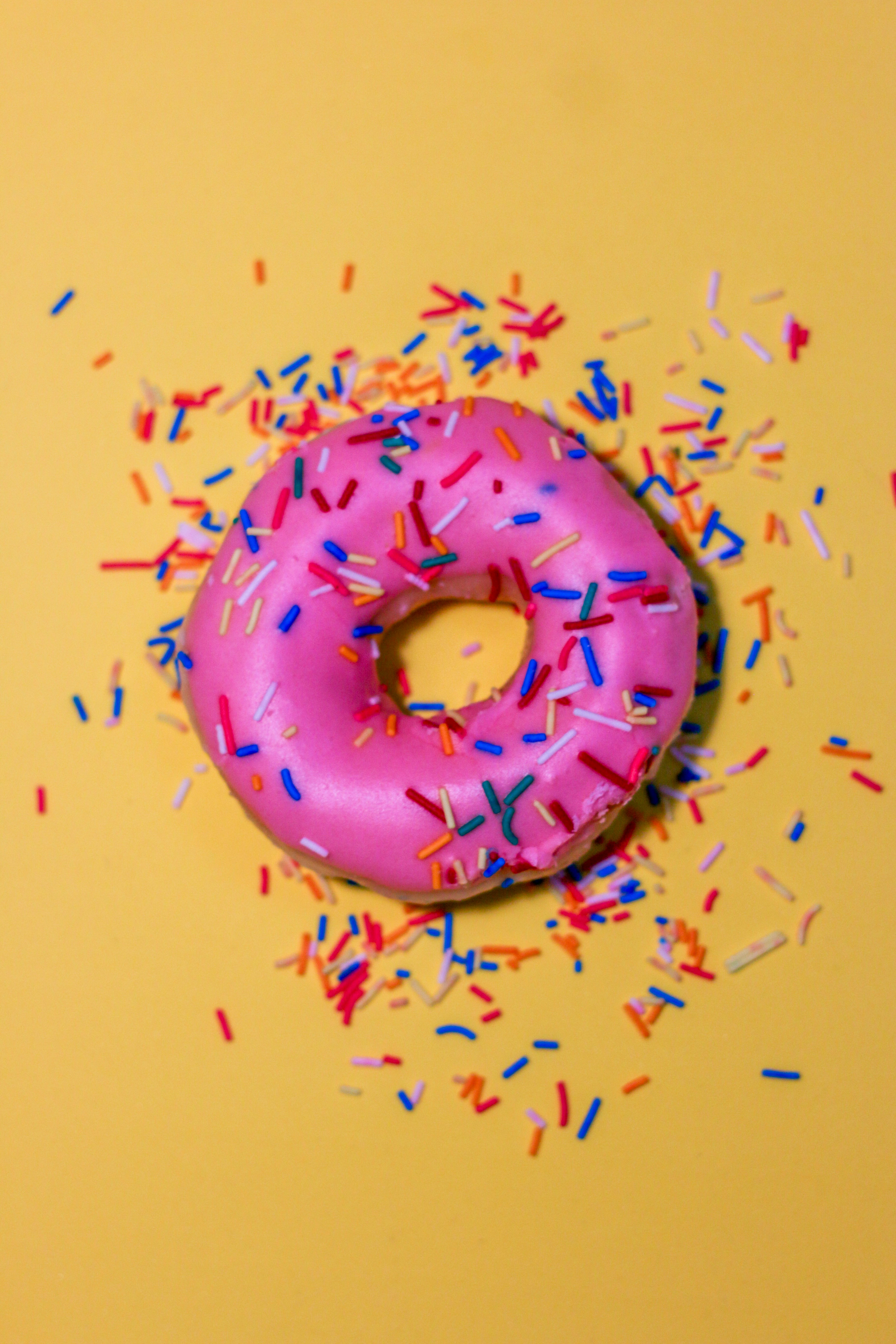 Pink Donut Blooming with Sprinkles Against Sunflower backdrop