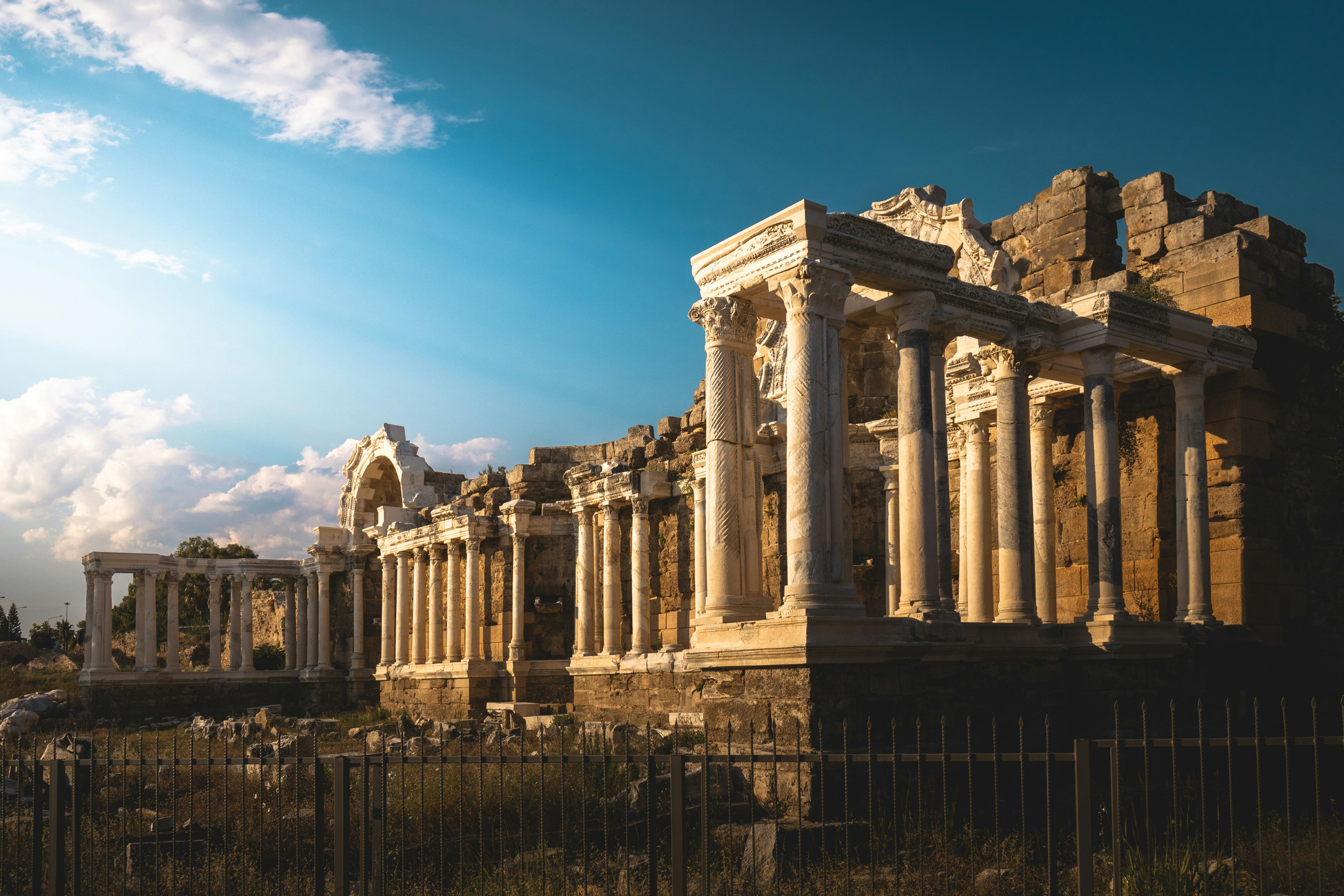 Majestic ancient ruins with columns under a bright blue sky.