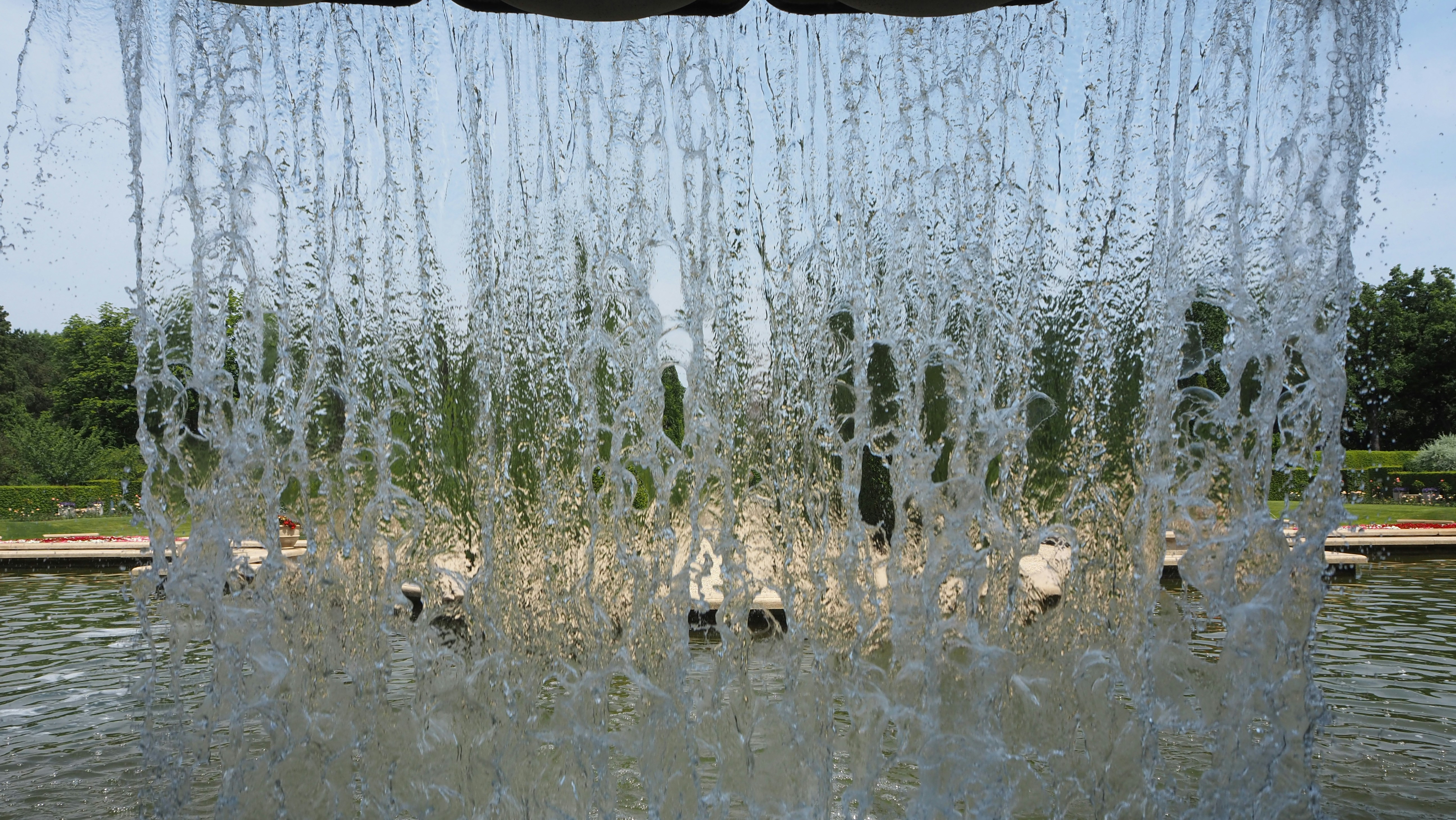 Frosted Curtain over a Quiet Lake: Waterfall of Ice in a Park