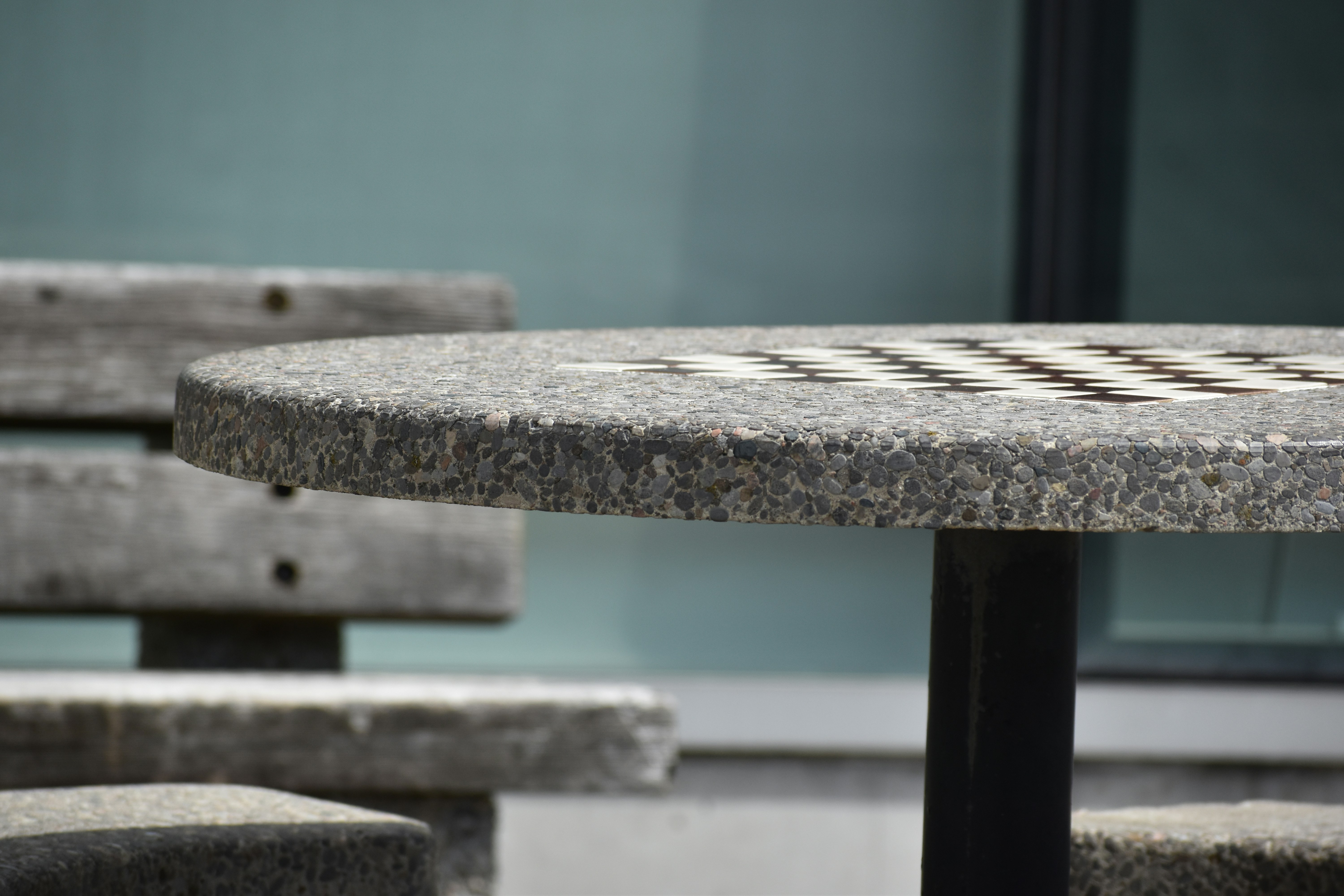 A granite table with a chessboard and a matching bench.