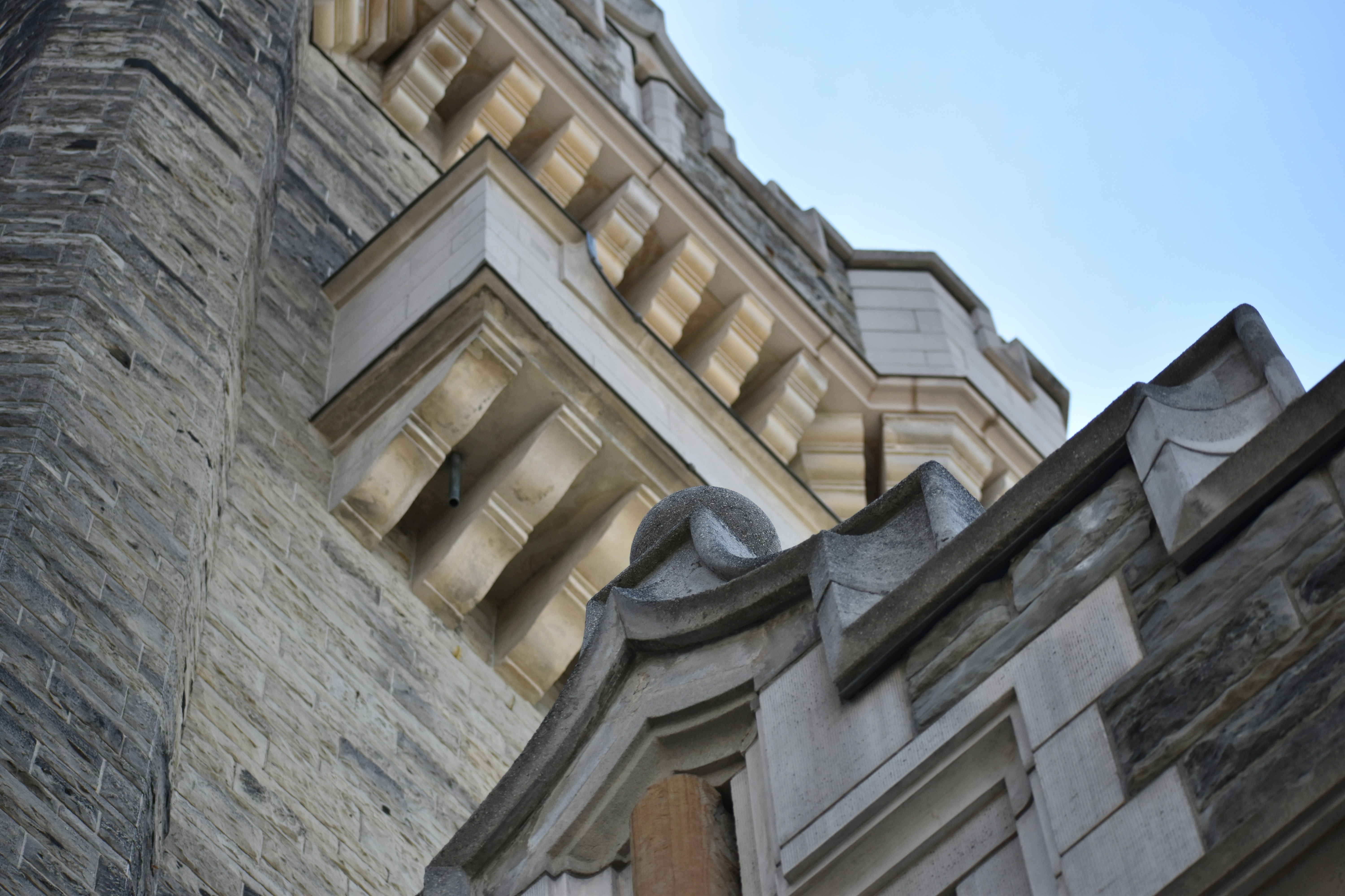 Castle Corner: Weathered Stone and Battered Cornice Under Clear Sky