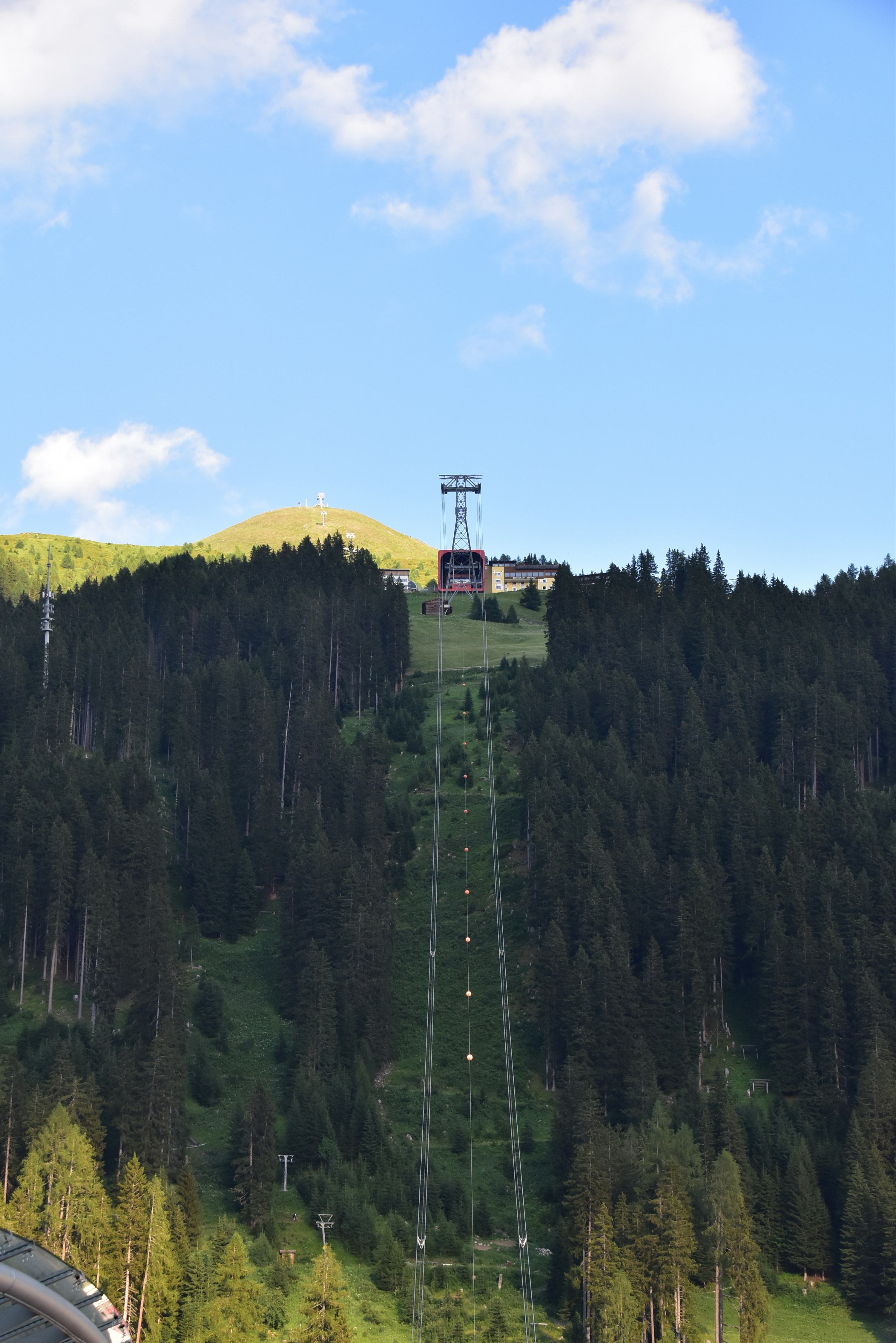 Cable car ascent toward the sunlit hilltop