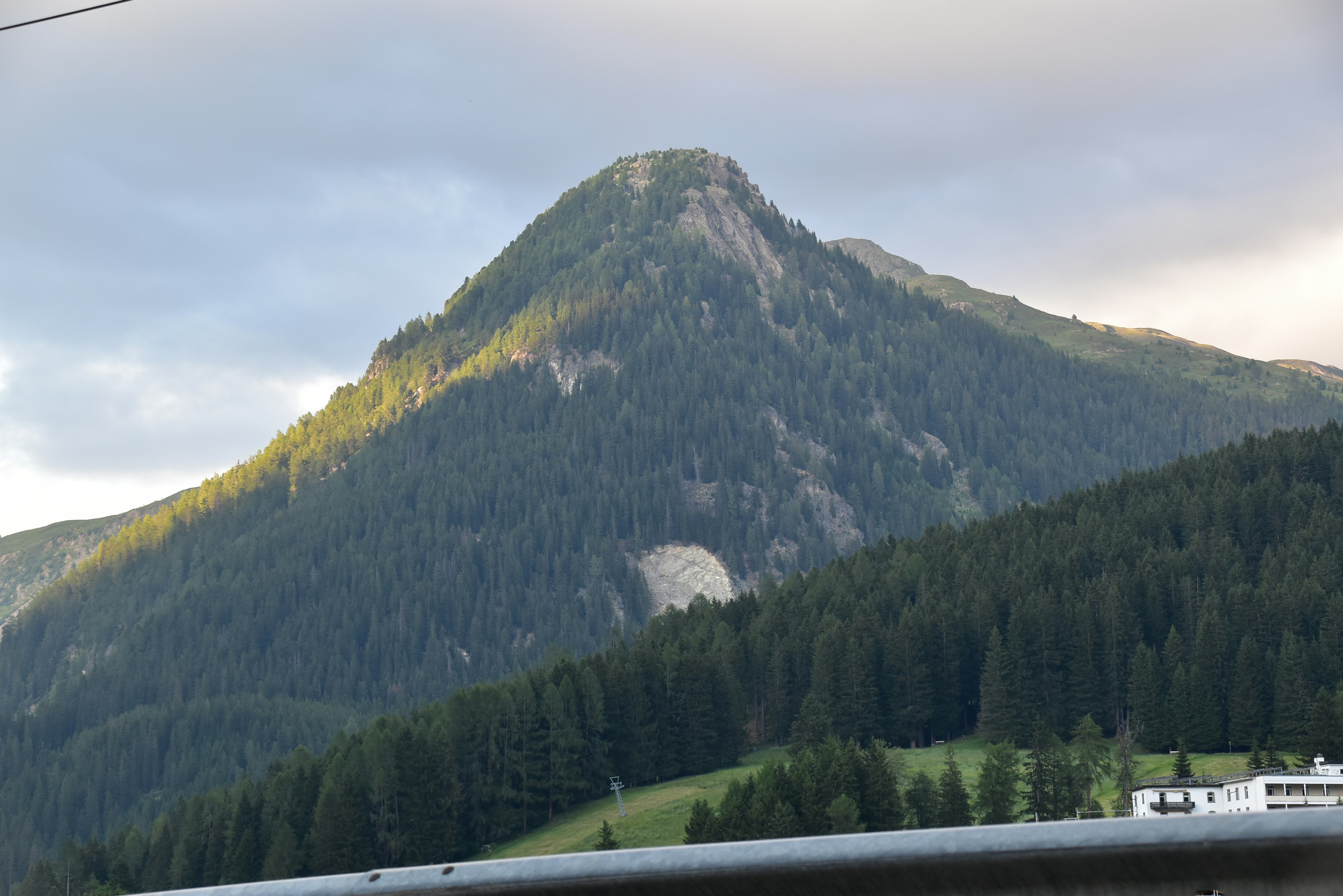 Sunlit Summit: A Forested Peak Rising Over a Quiet Valley