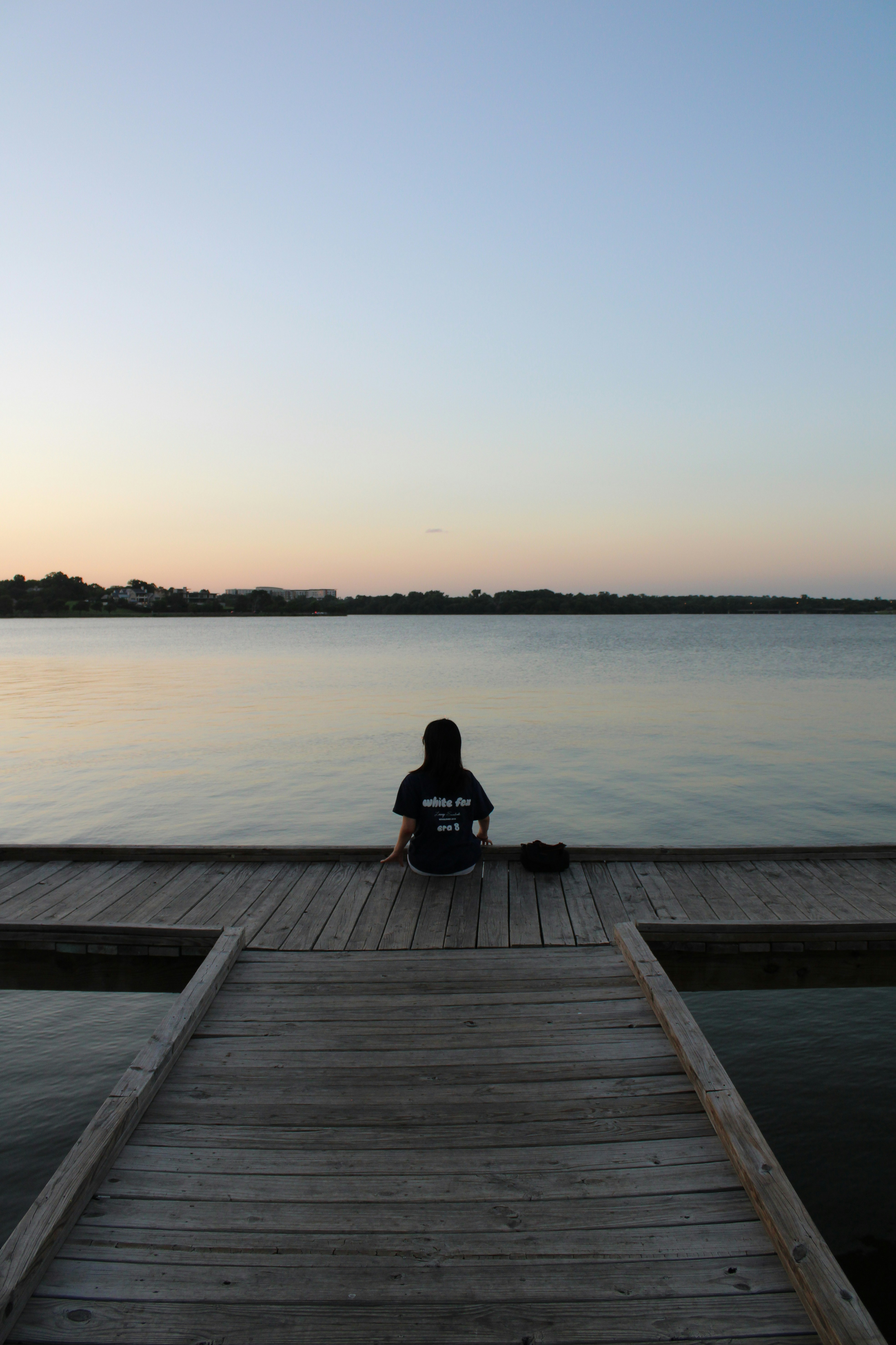 Silhouette at the Edge: A Quiet Moment on the Dock at Dusk