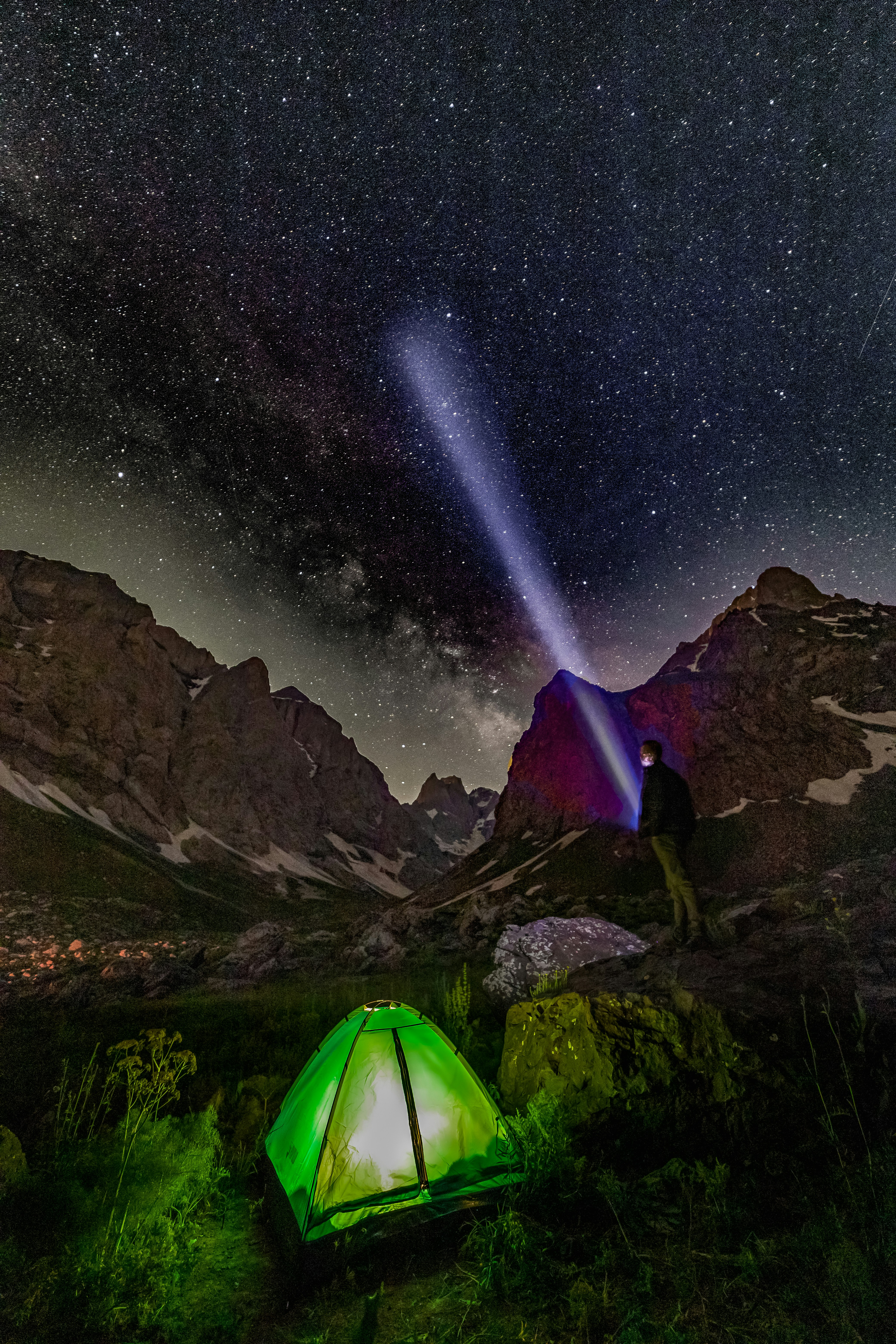  guiding beam over jagged slopes under a Milky Way canopy