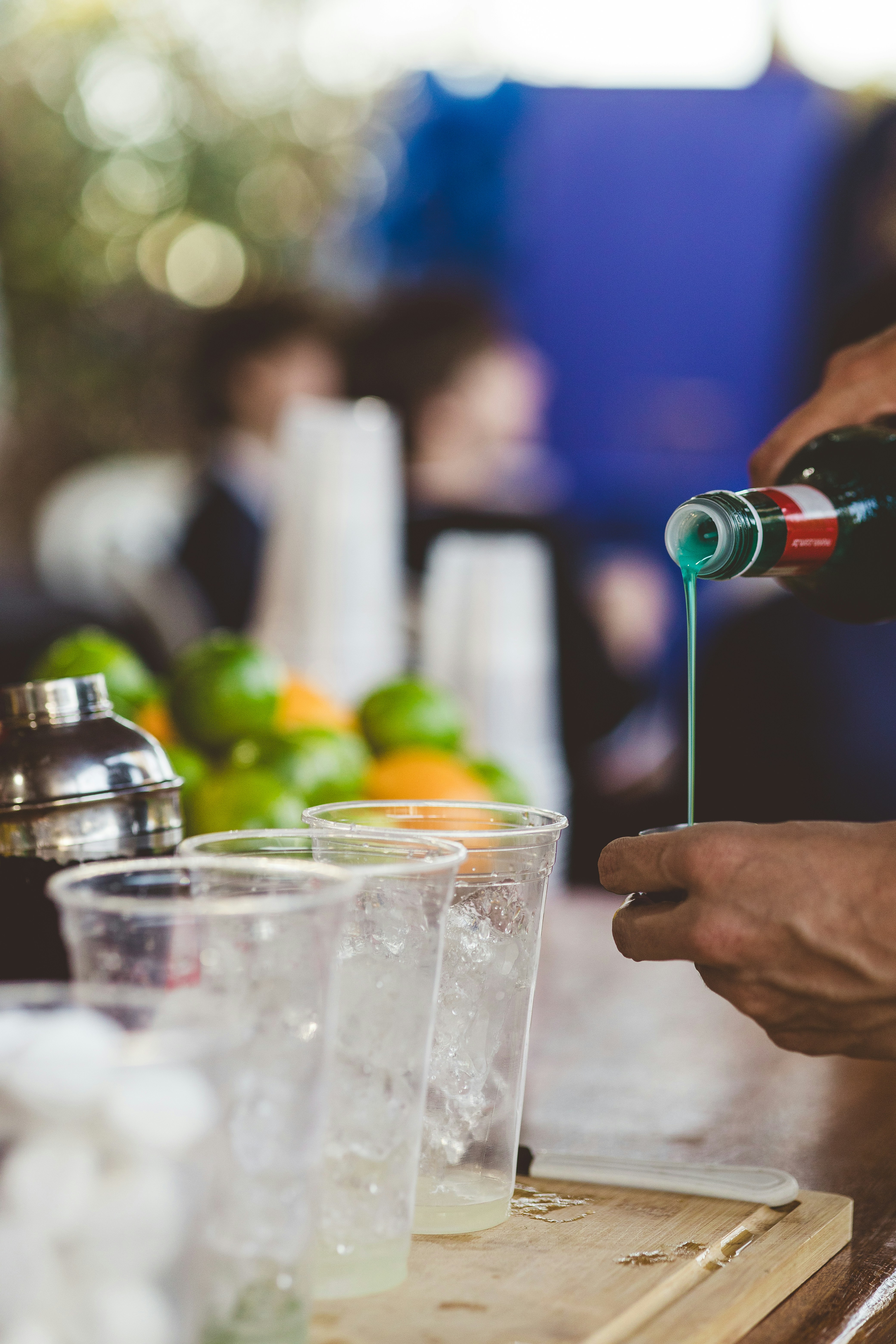  pouring green cordial into a clear cup at a vibrant beverage bar