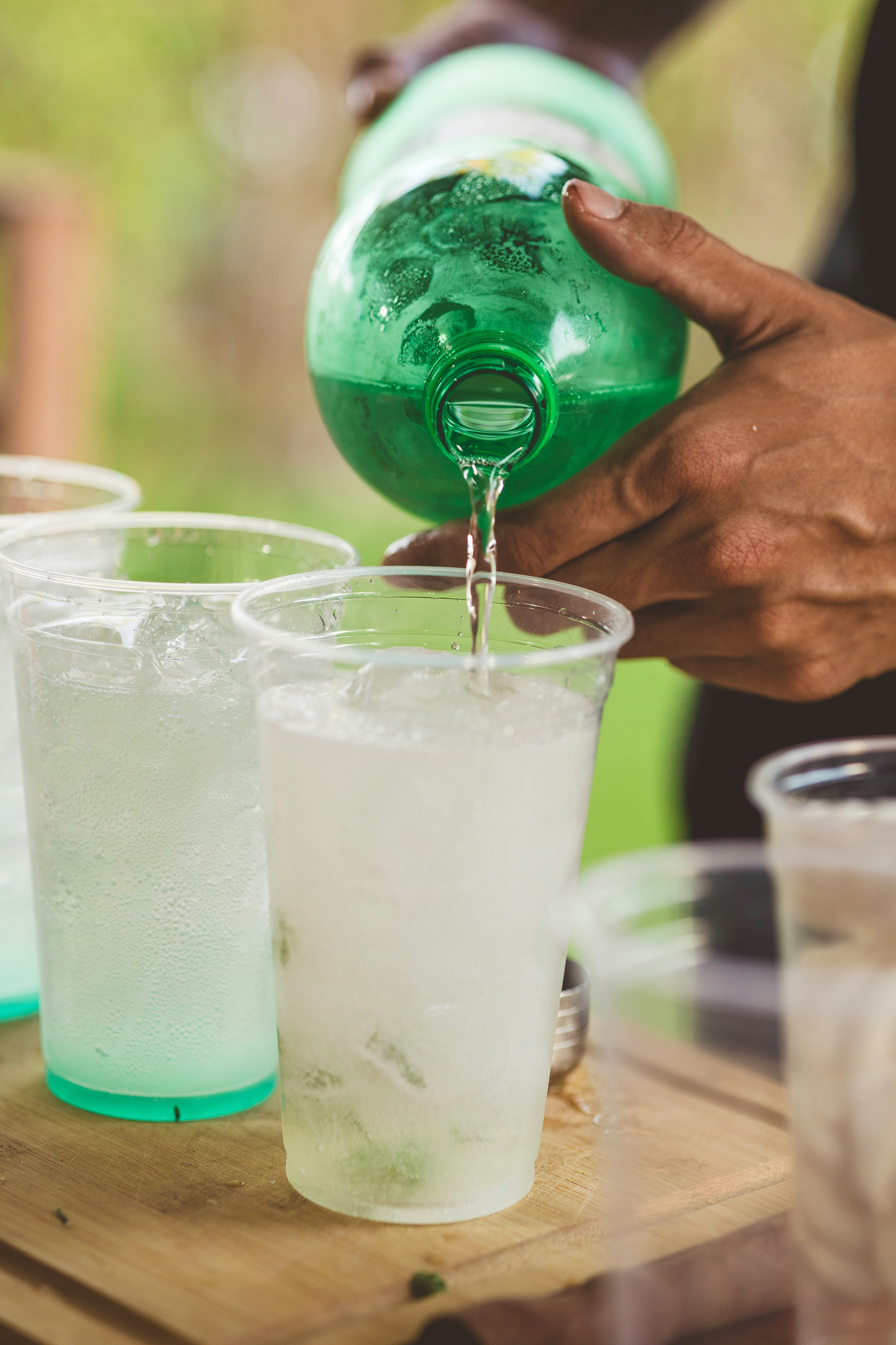 Pouring Green Bottle Over Ice: A Hands-On Summer Moment