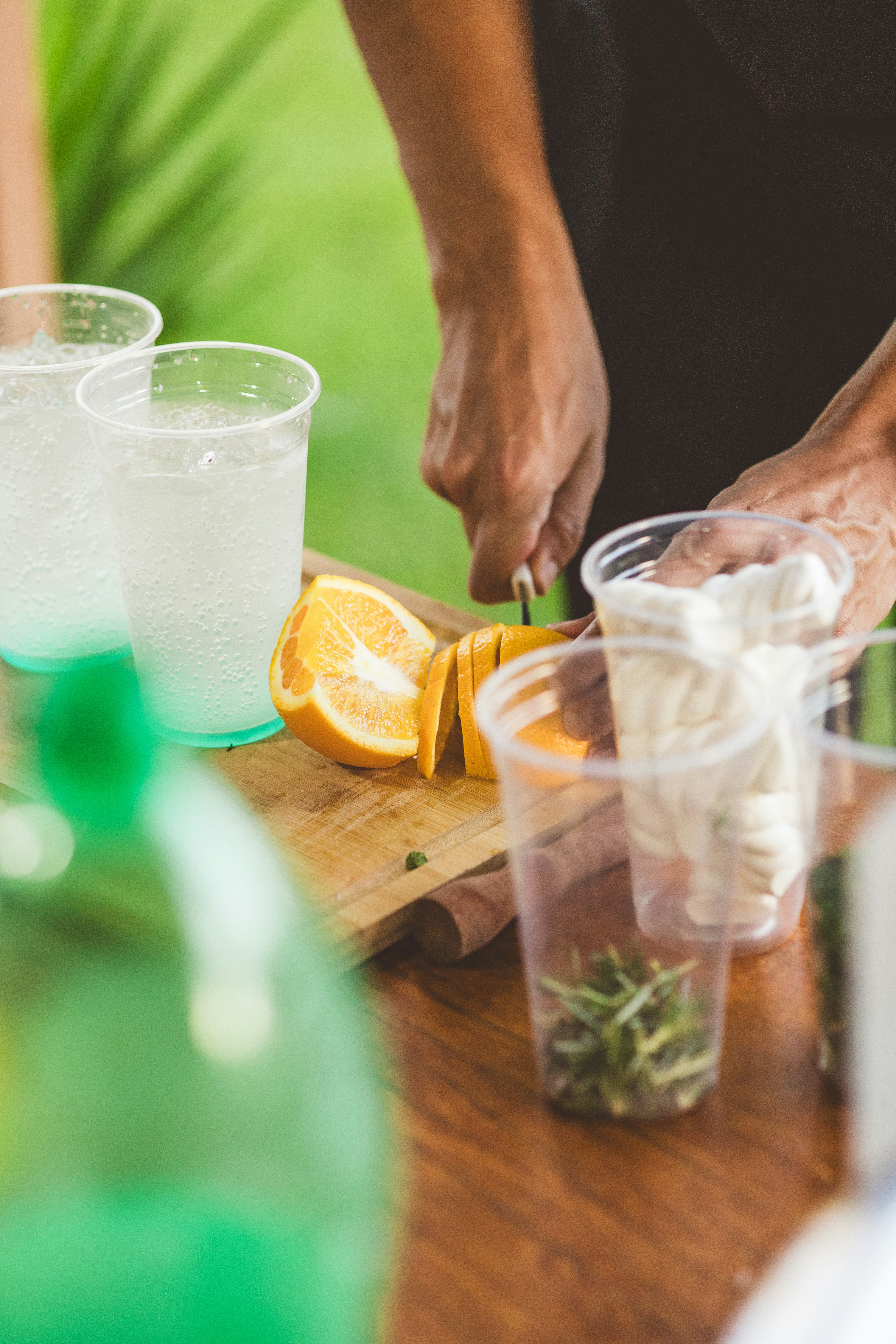 Citrus Prep in Action: Hand Slicing Oranges at a Vibrant Bar Counter