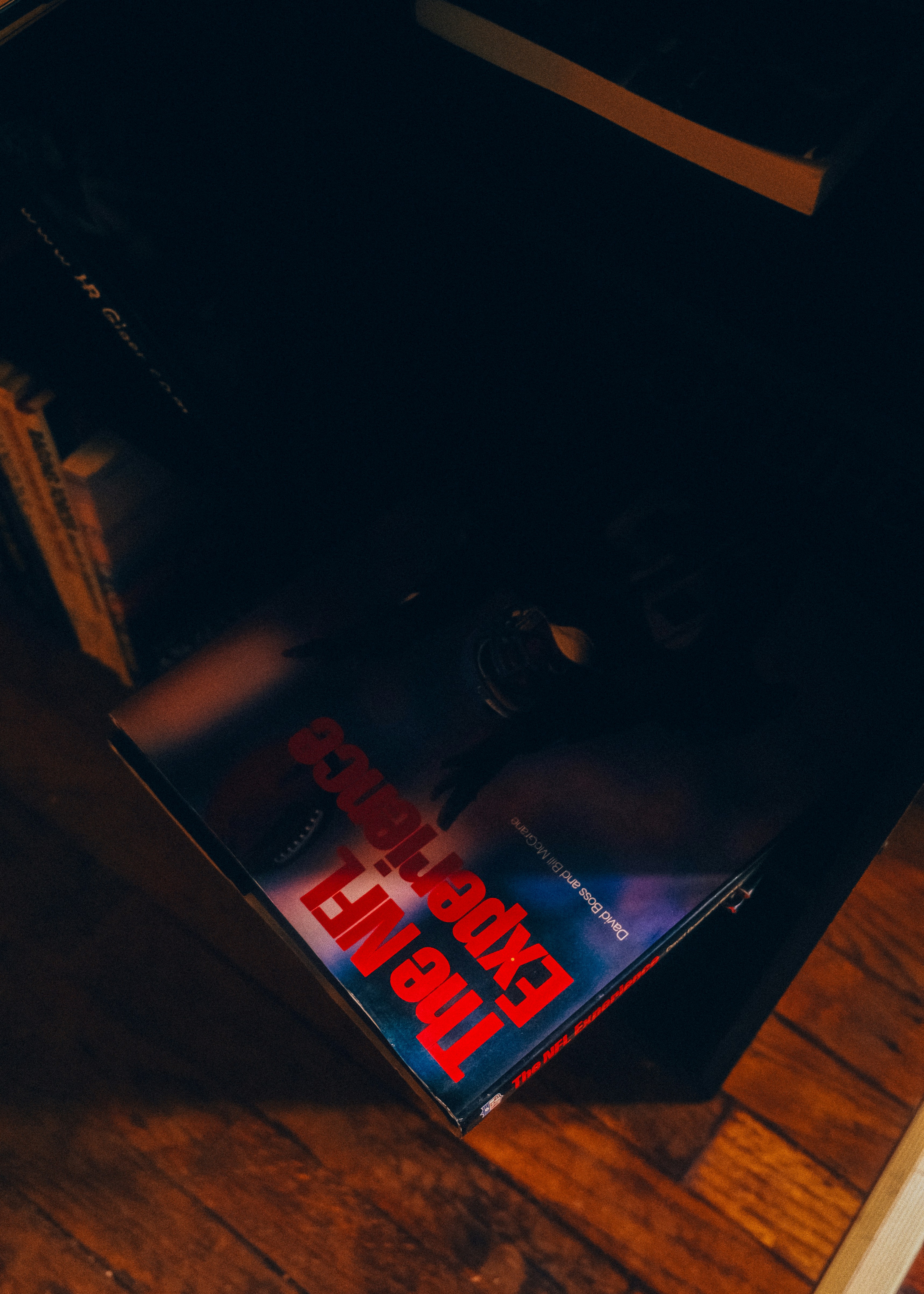 Dimly Lit Shelf Scene: A Probable Magazine and Shadowy Accessories