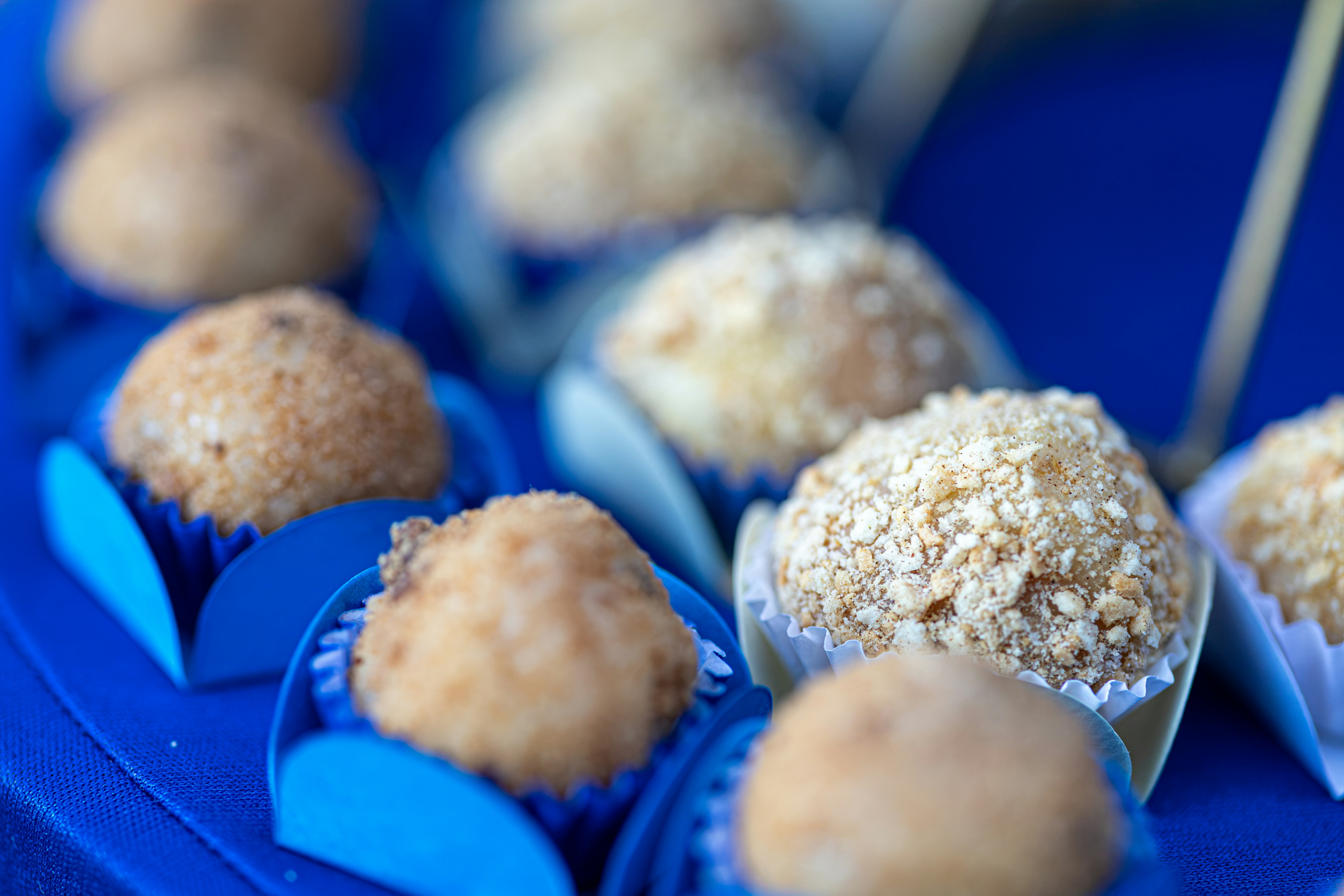 Blue-ribbon Bites: Assorted Cream-Topped Pastries on a Velvet Table