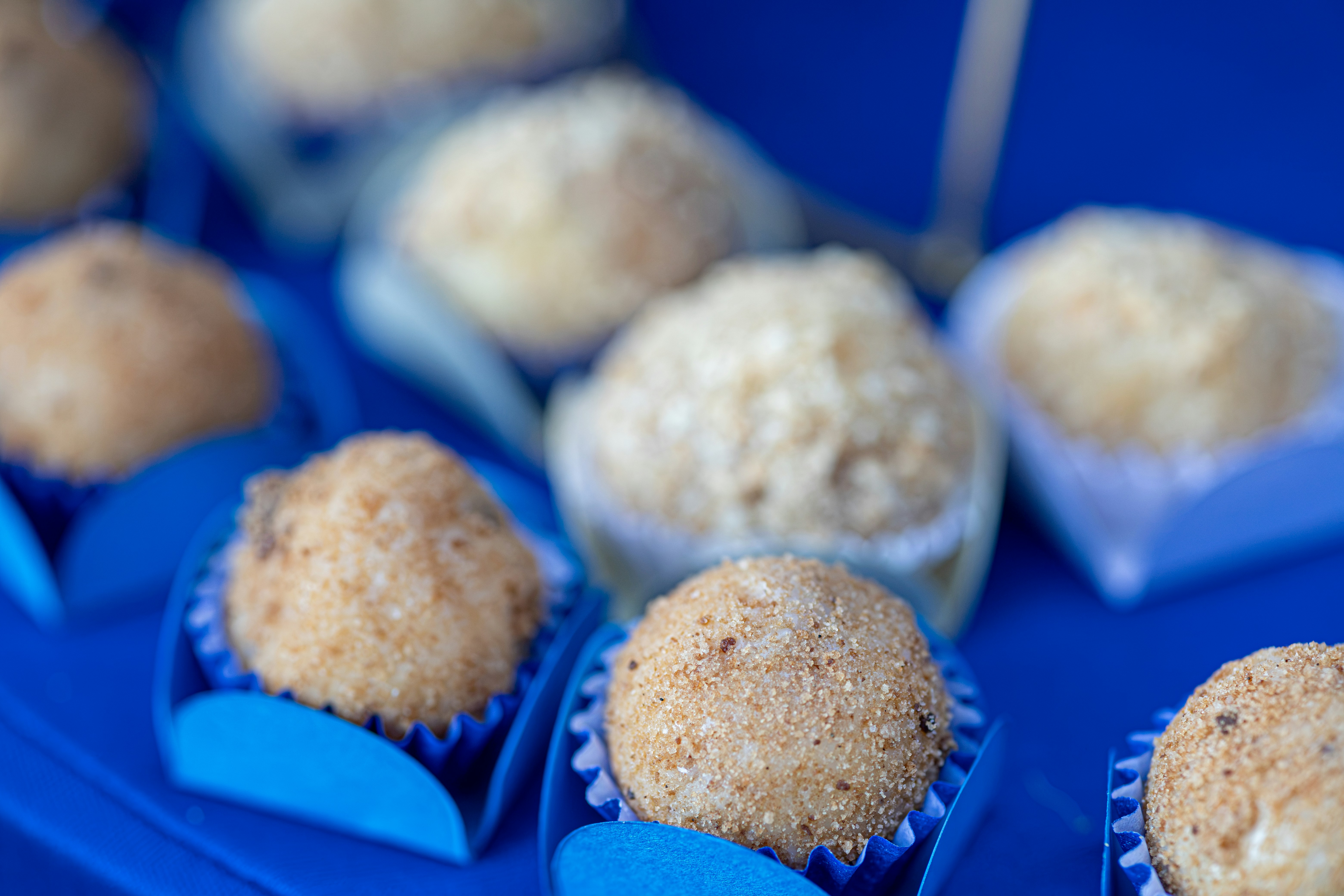 Sweet, crumb-coated desserts in blue paper cups.