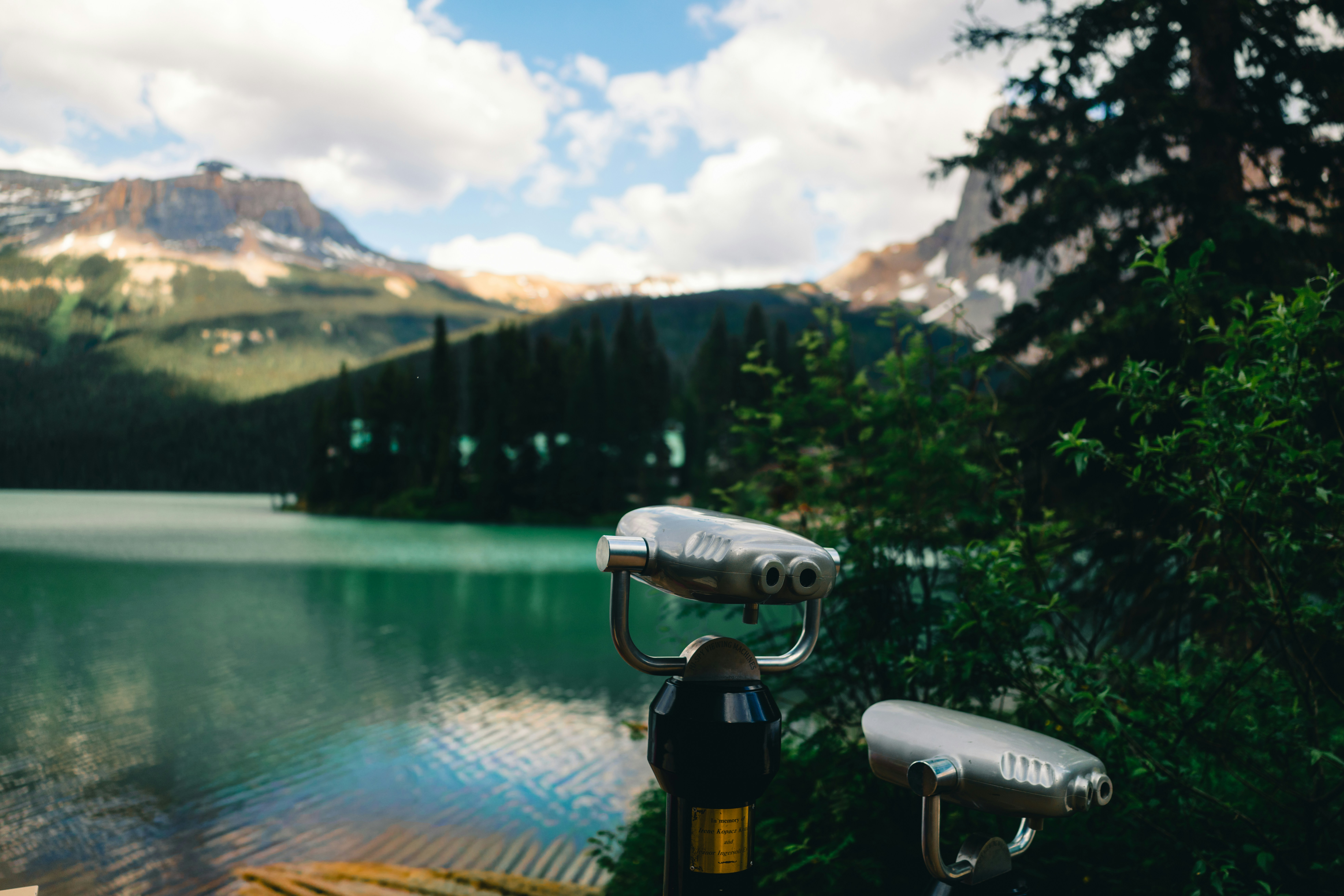 Twin scopes on a lakeside lookout overlook a tranquil alpine lake