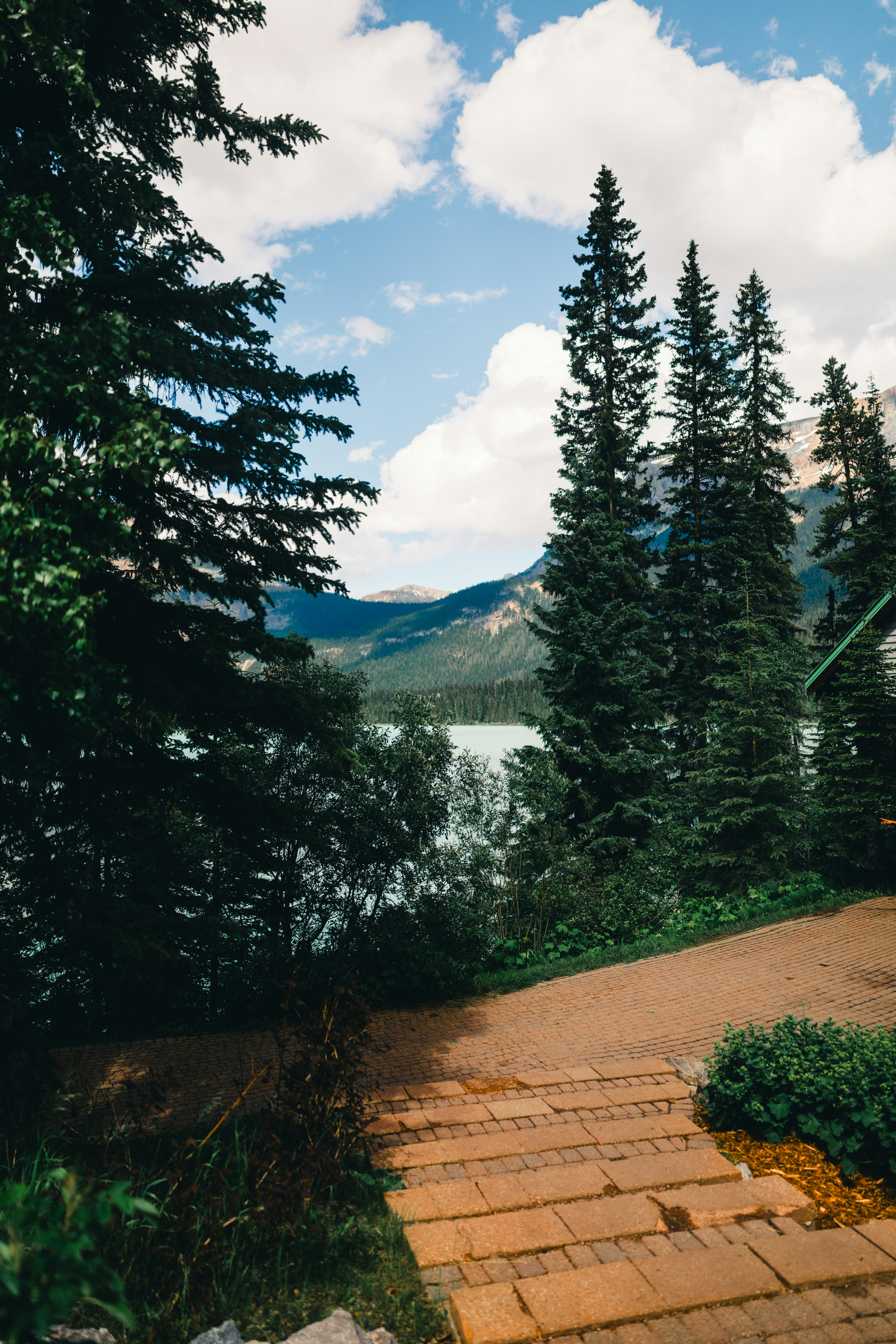 Brick Terrace Meets Lakefront Pines Under Alpine Sky