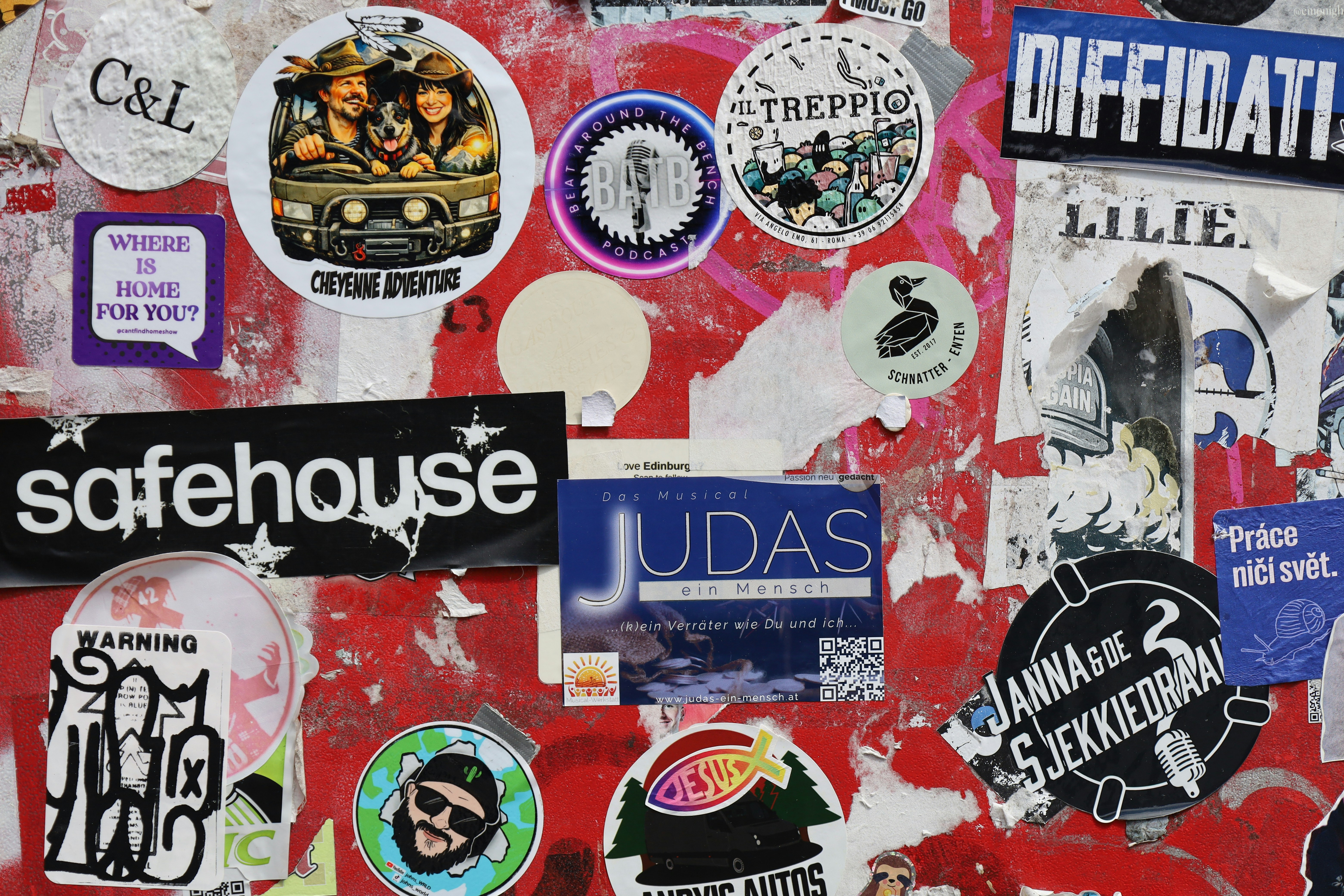 Sticker Mosaic: A Busy Red Wall of Urban Patches