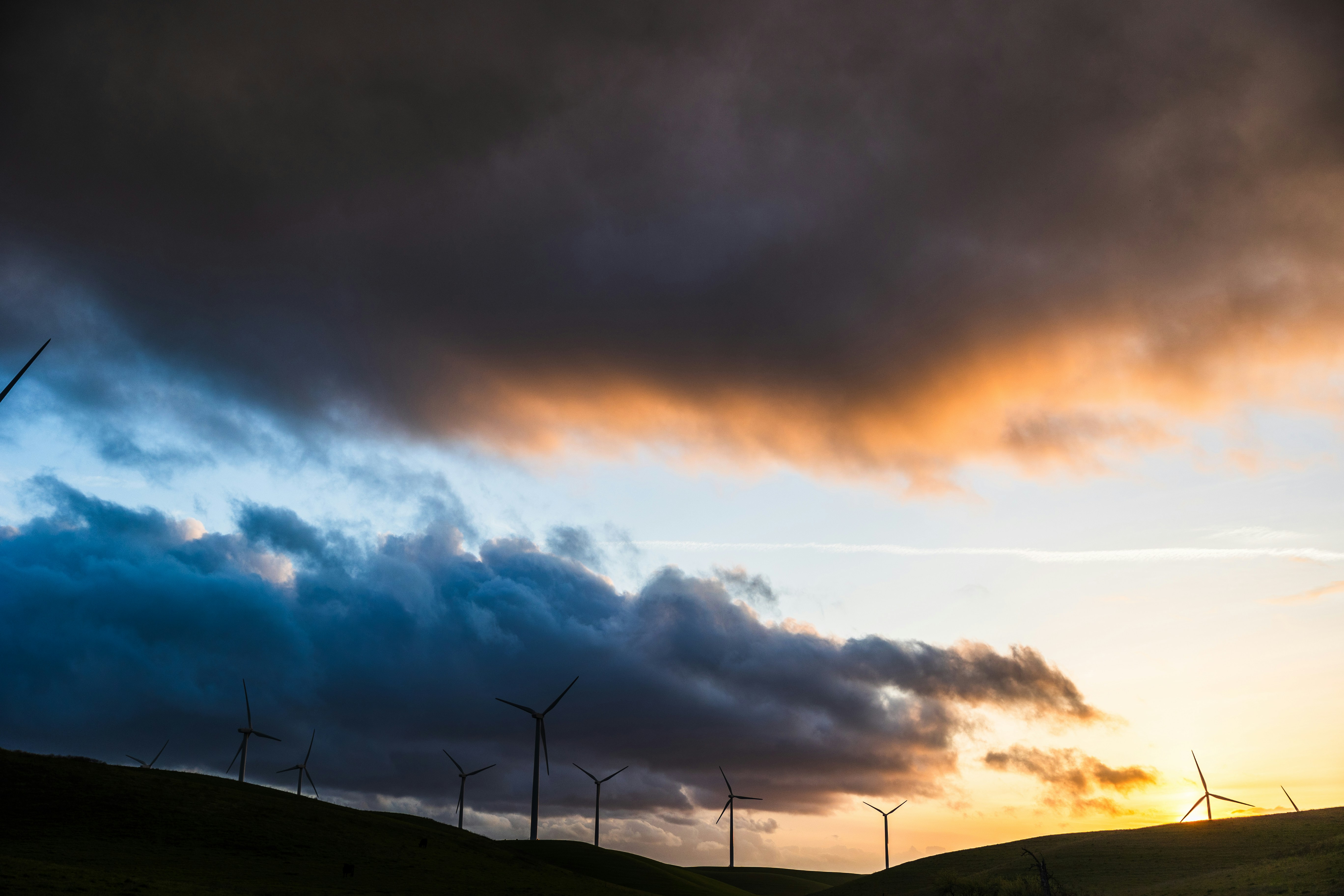 Wind Turbines at Dusk: Silhouettes on a Rolling Horizon