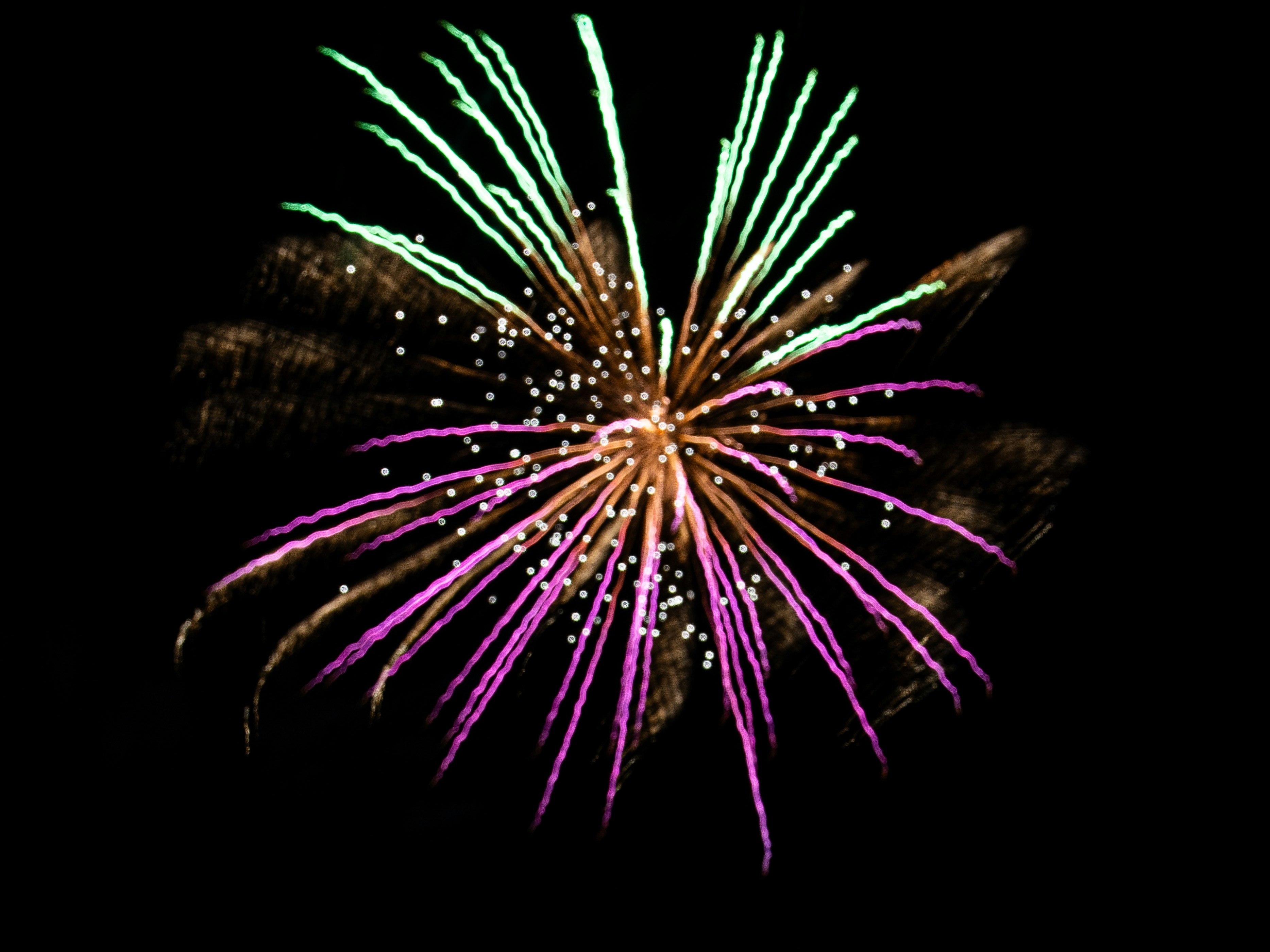 Mid-Flight Bloom: Multicolored Firework Center Sparks Against Night