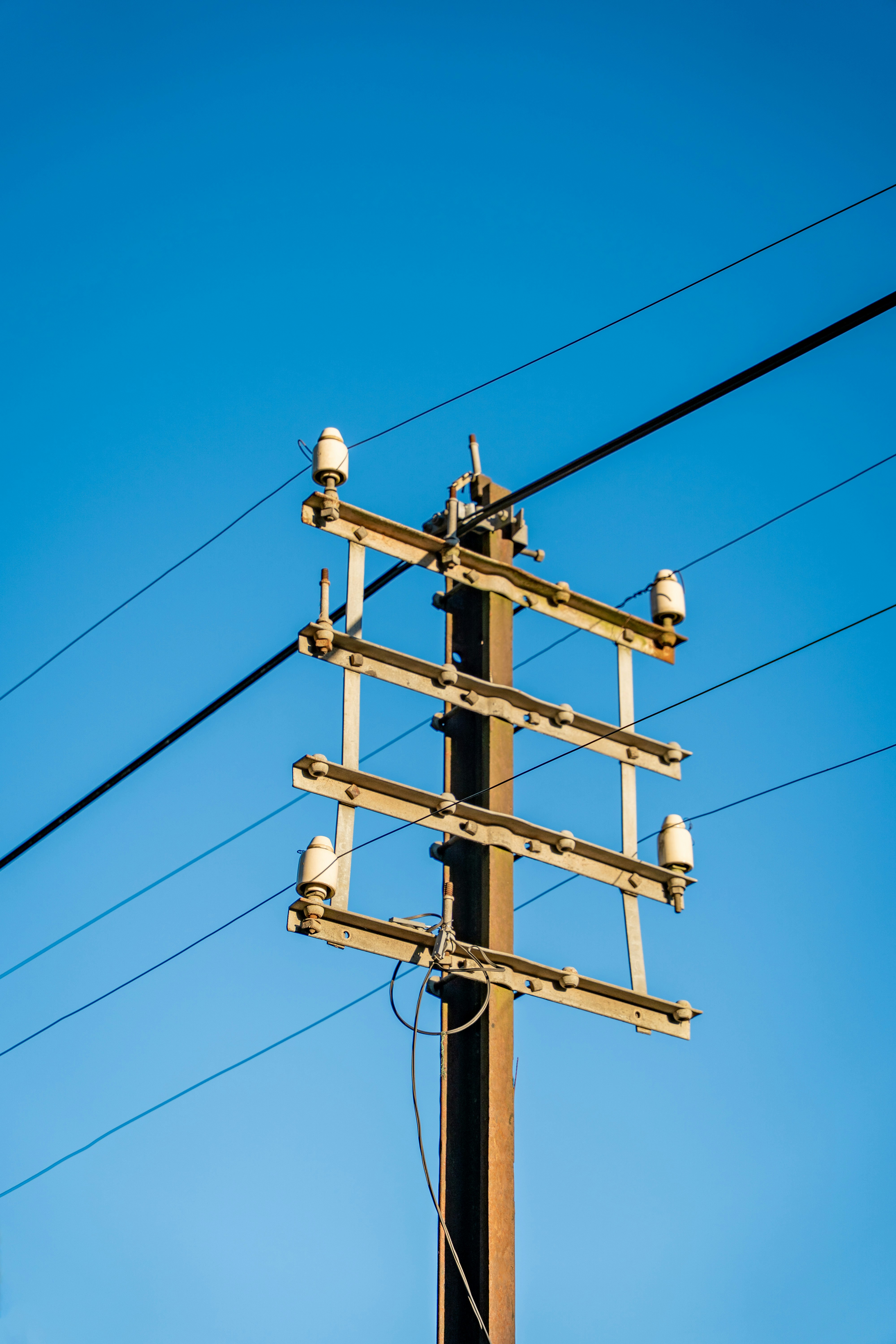 Pole of Silence: A Steel Utility Tower Against a Forged Blue Sky
