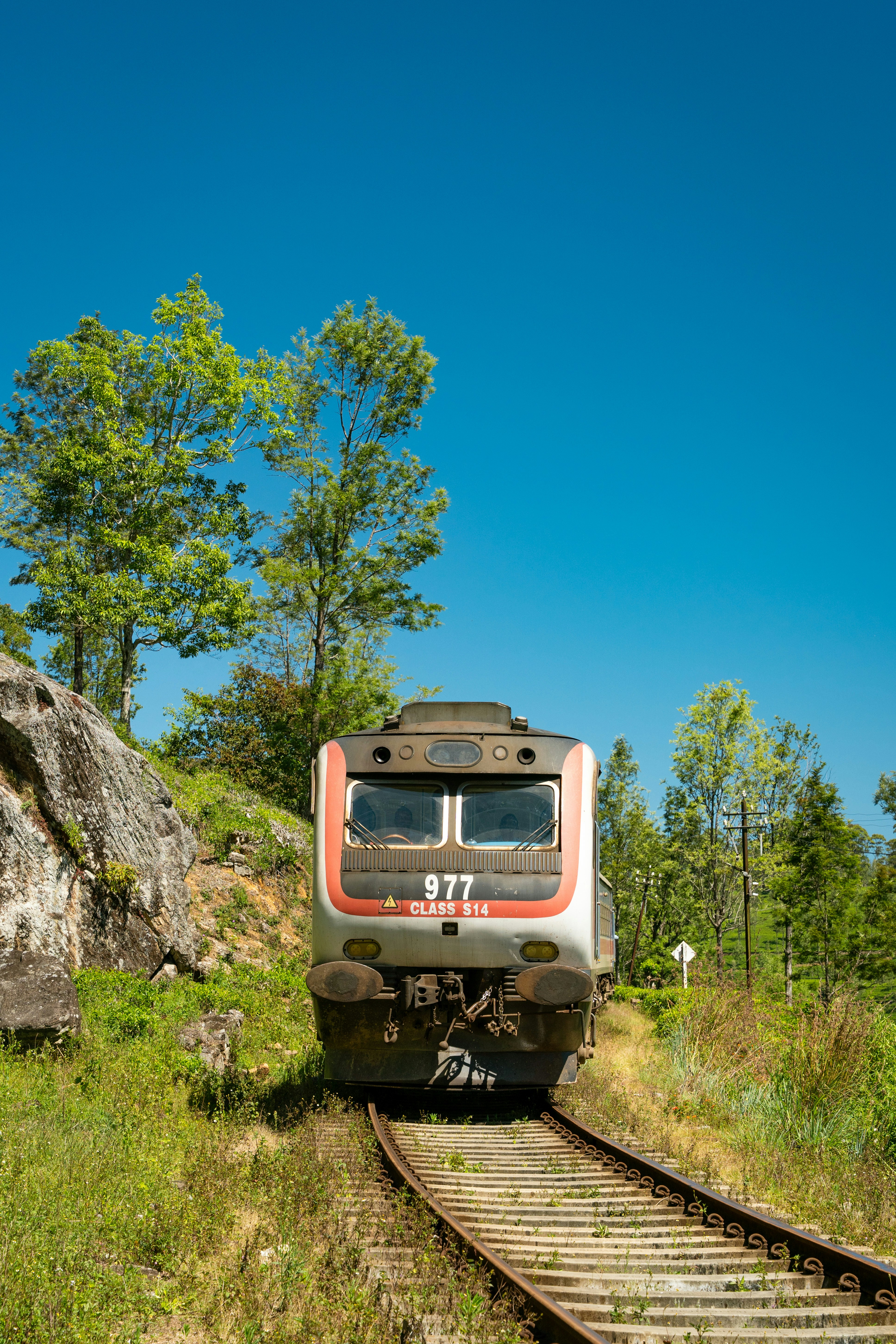 Locomotive on Narrow-Gauge Rails Slicing Through Green Hills