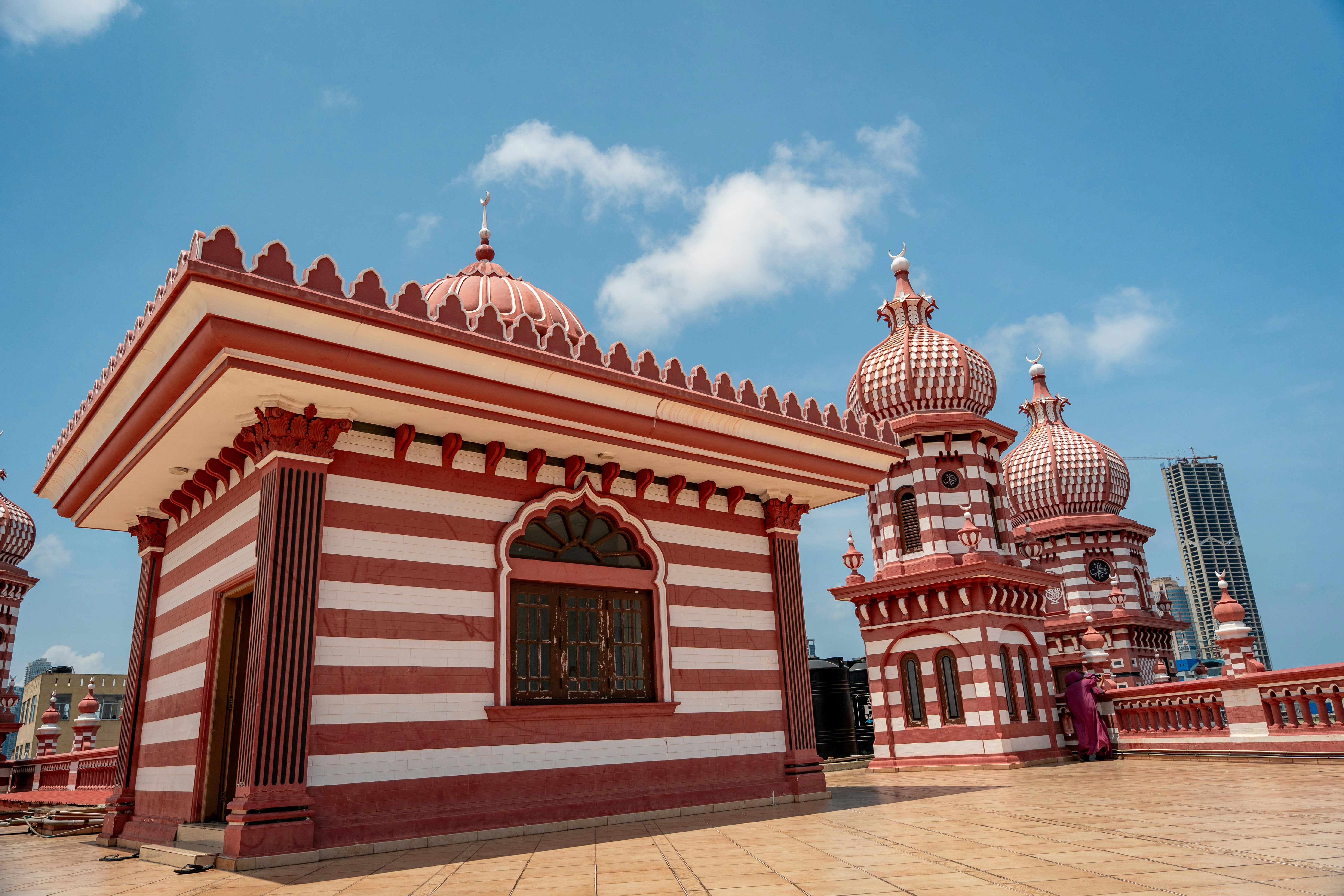 Striking red and white striped building with domes.