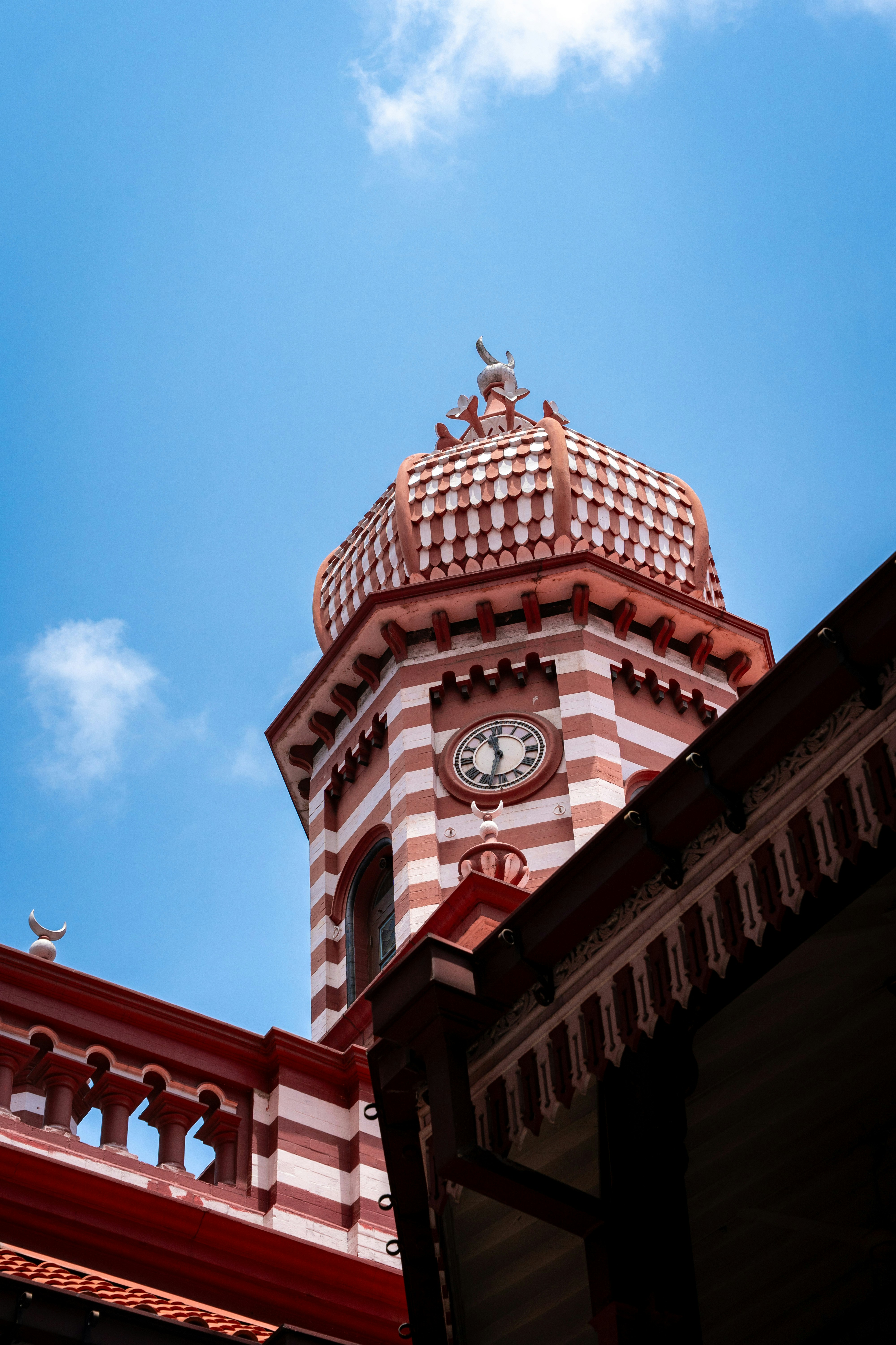 Clocktower Crowned in Red Tiles Under a Bright Sky