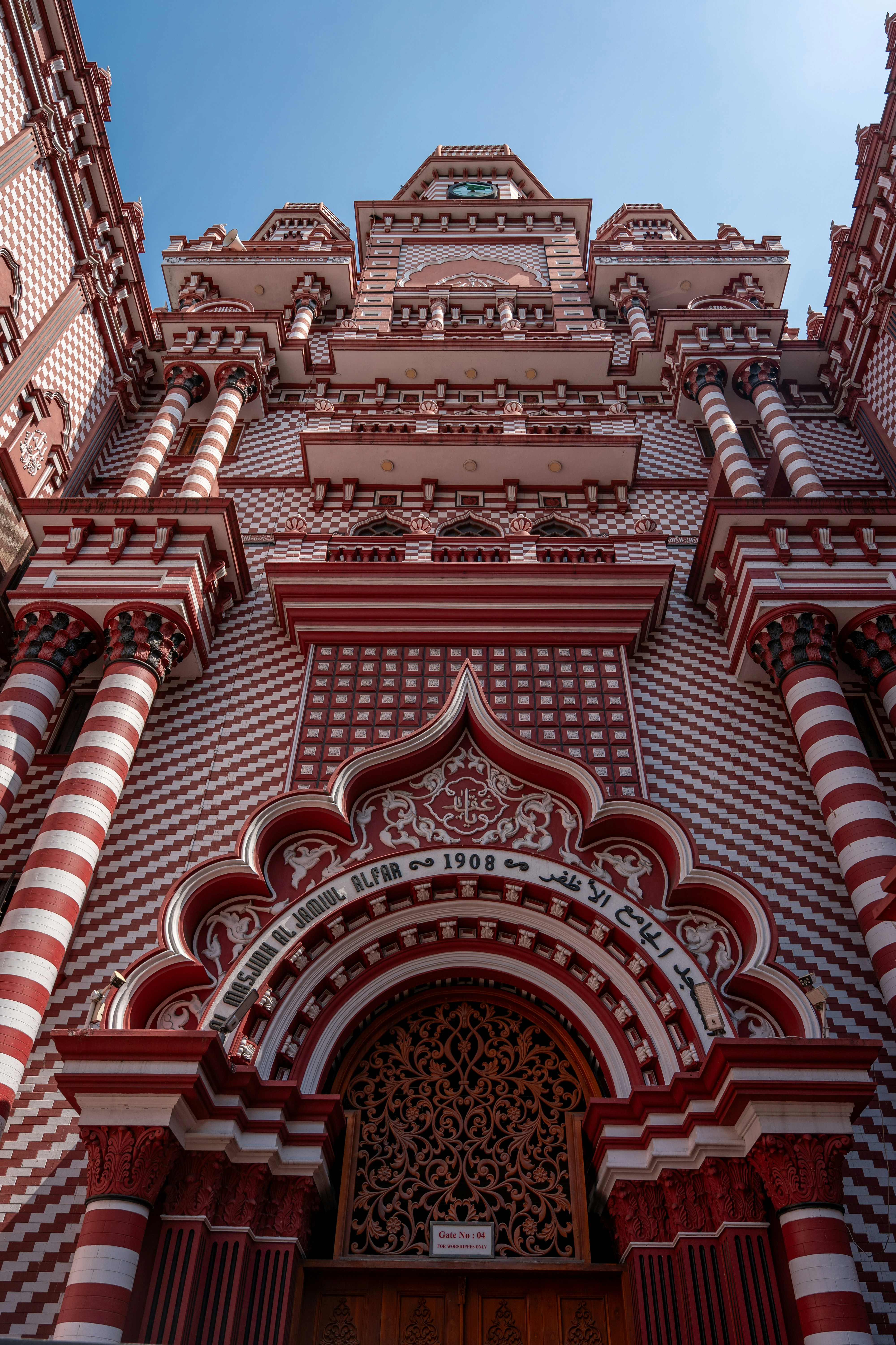 Rippling Red-and-White Facade: A Far-Tlying Perspective of the Lahore Style Archway