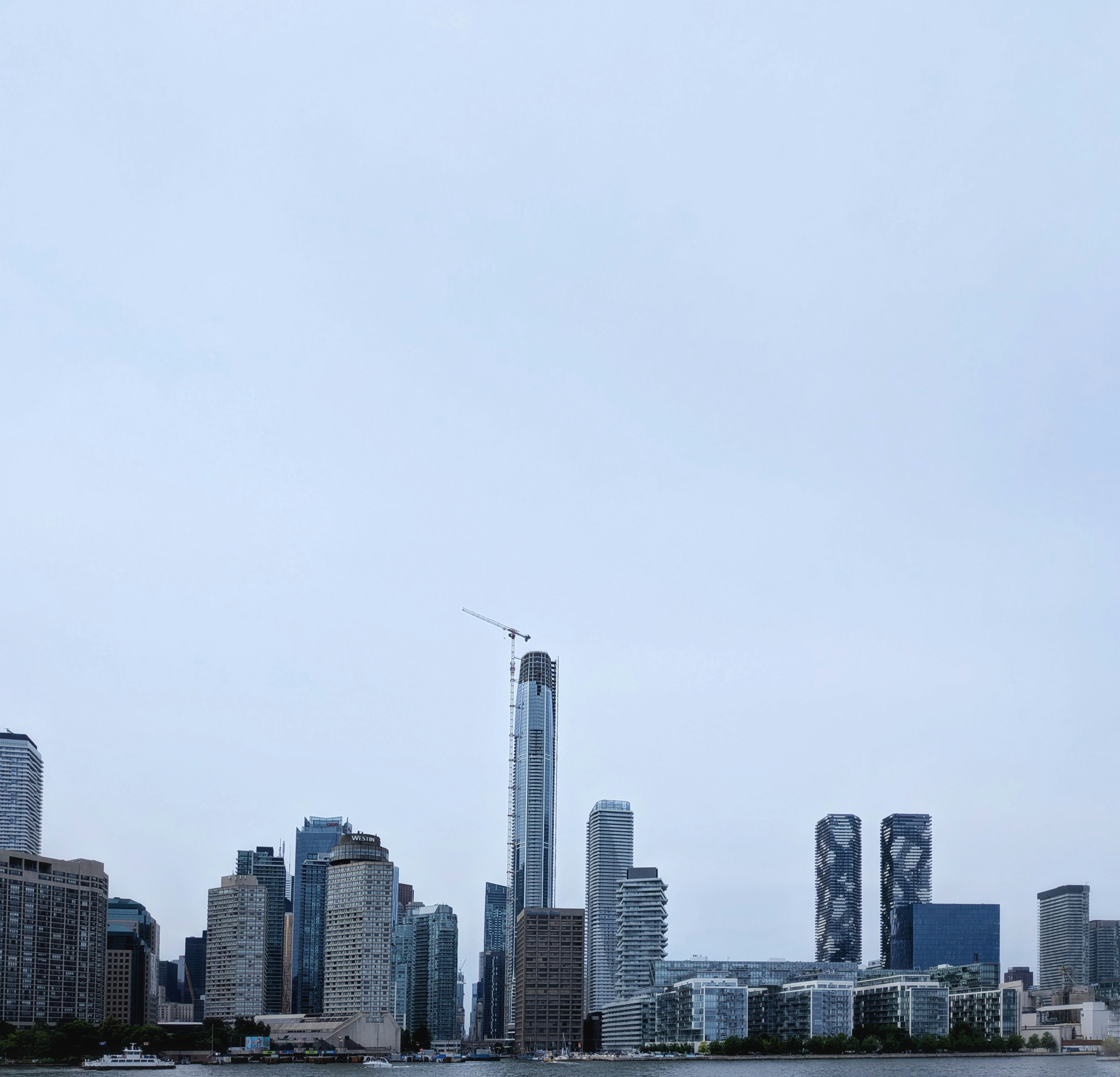 Tallest Crane and City Skyline Rising over the Waterfront