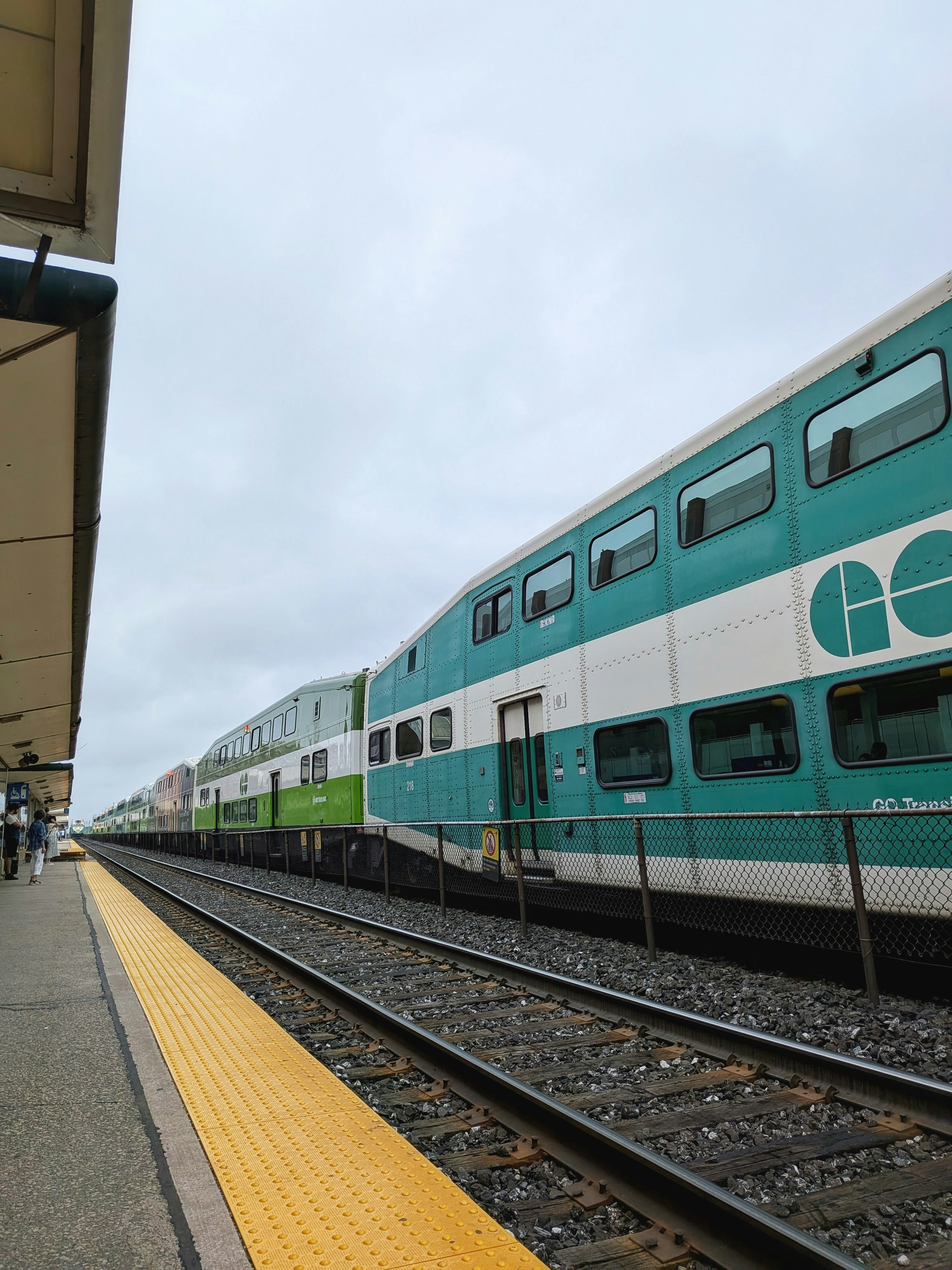  teal commuter train at a sunlit station