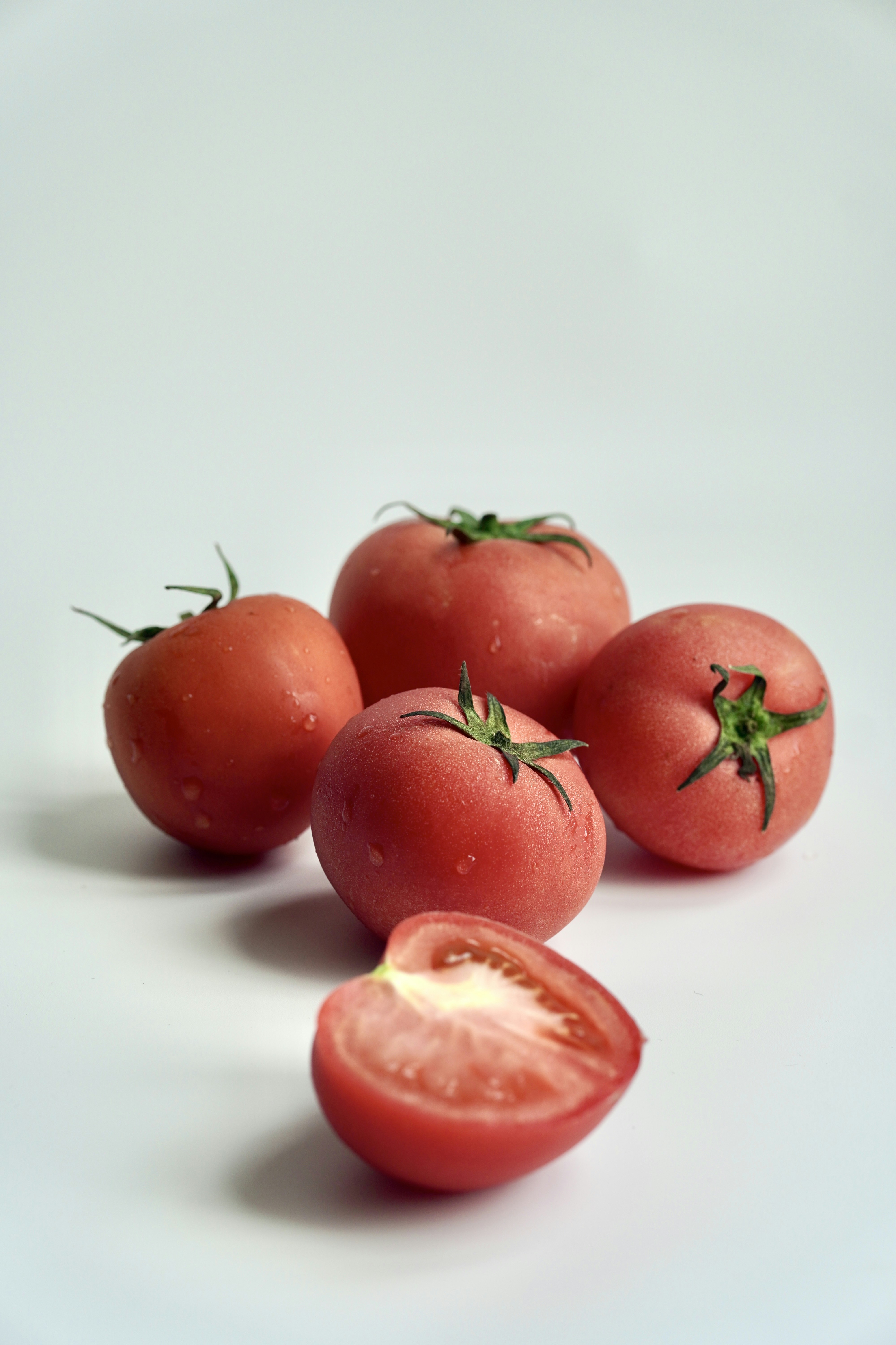 Curved Cluster of Red Tomatoes on a White Canvas