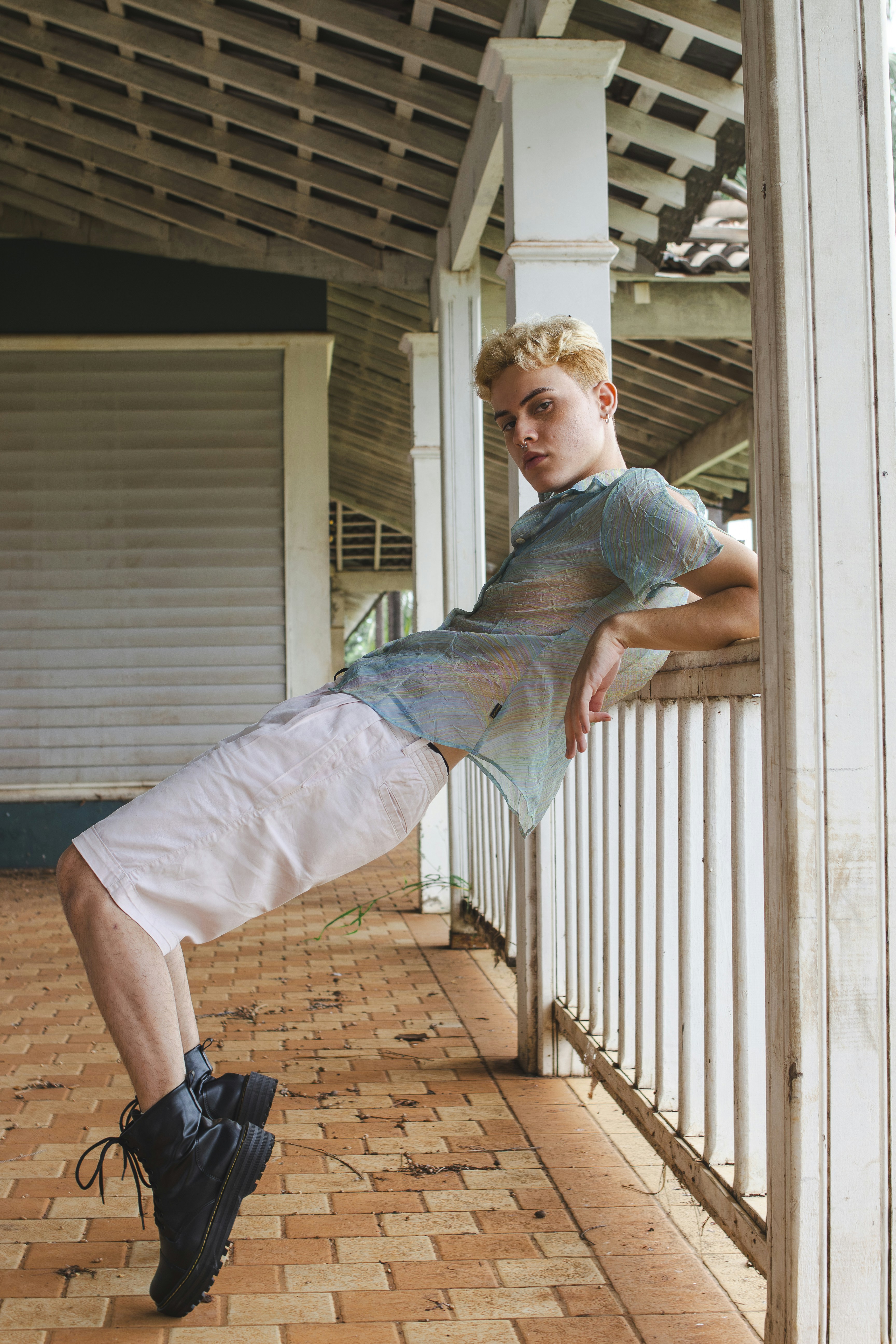 Casual defiance on the veranda: a sunlit portrait with an angled lean