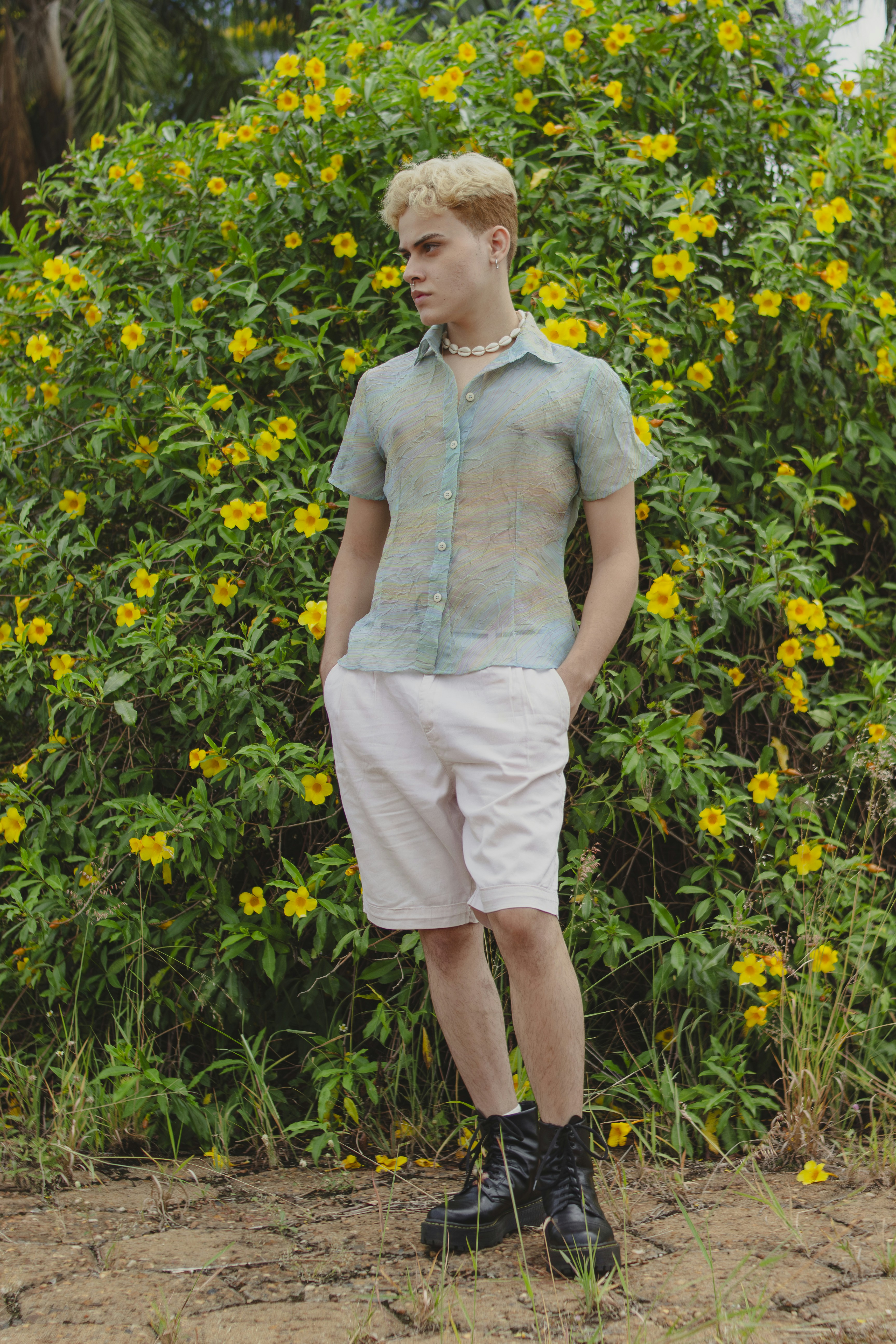 Sunlit Garden Stance: Youthful Portrait Among Golden Blossoms