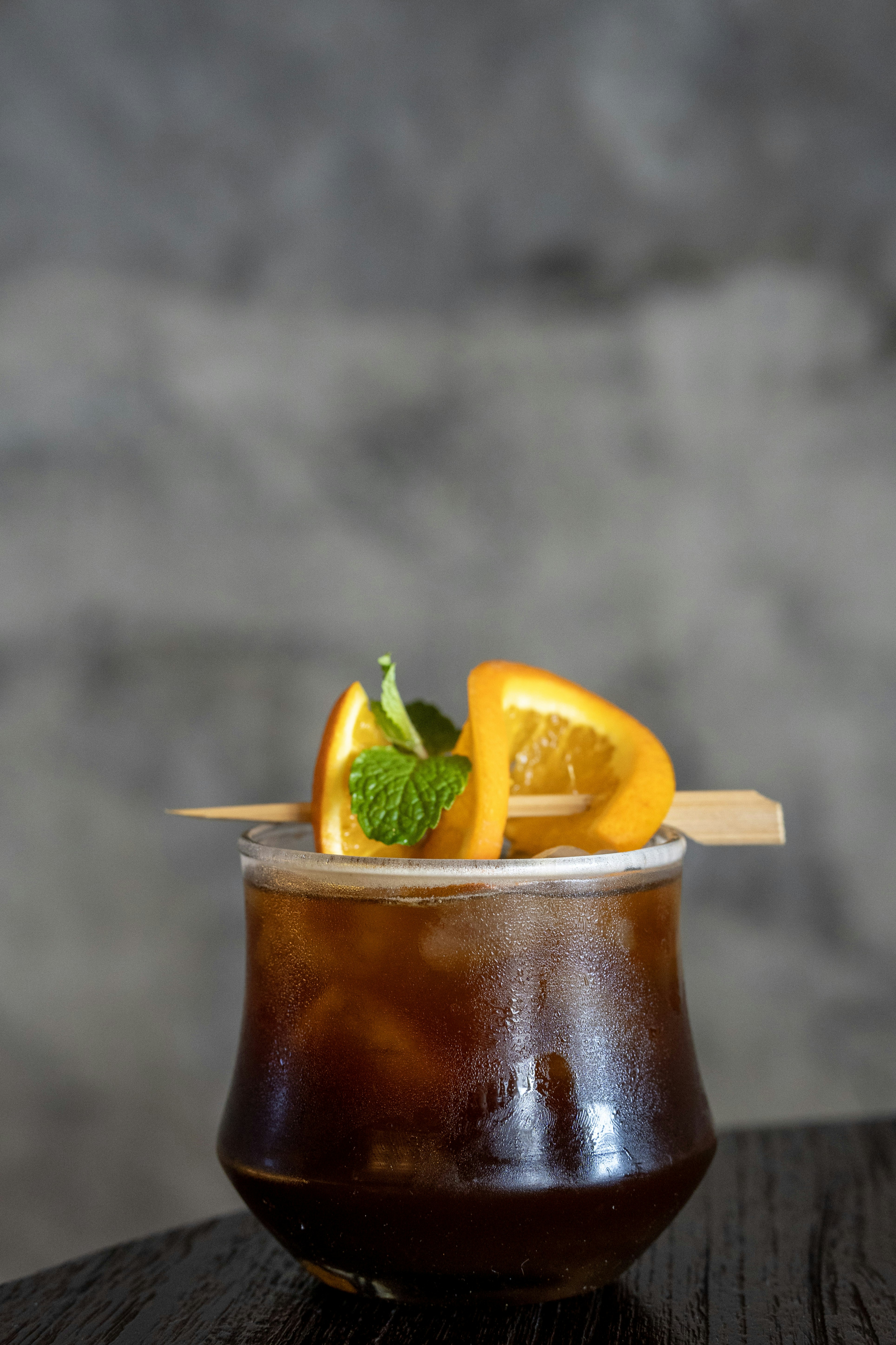 Citrus Kiss: A Dark Cocktail With Orange Garnish
