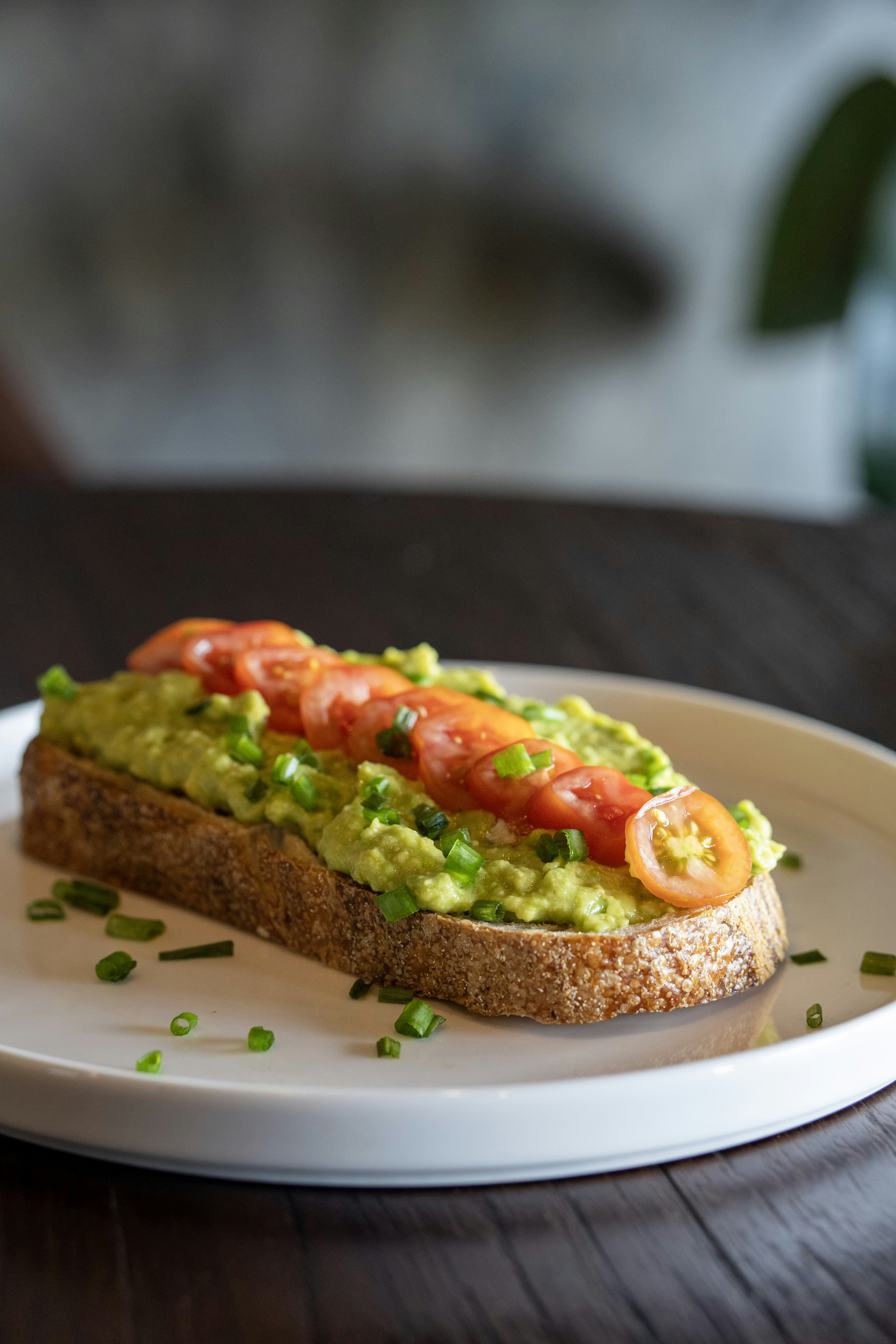 Guacamole Toast: Avocado Spread Crowned with Bright Tomato Slices on Rustic Bread
