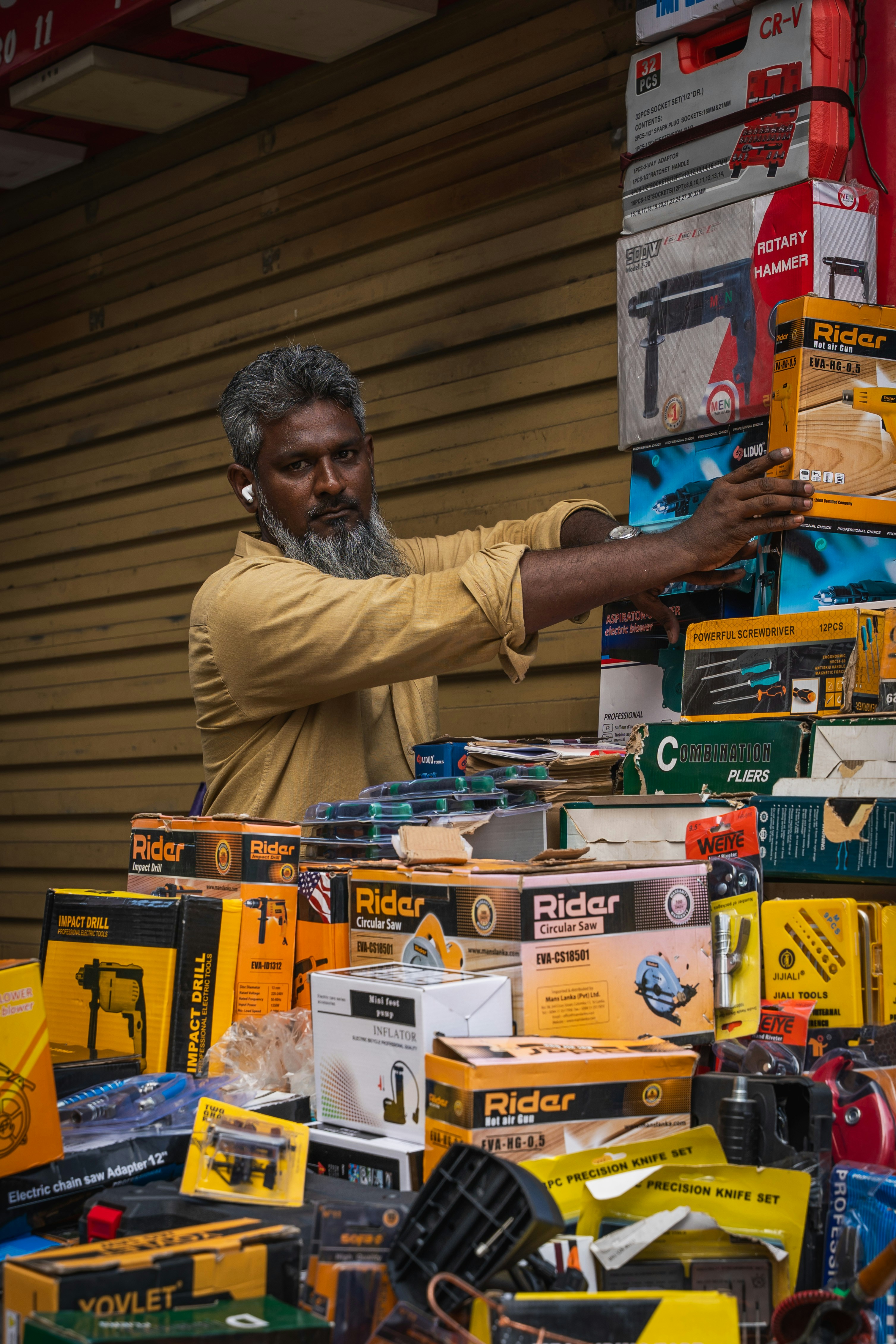 The Vendor Amid Stacks: A Moment of Manual Labor