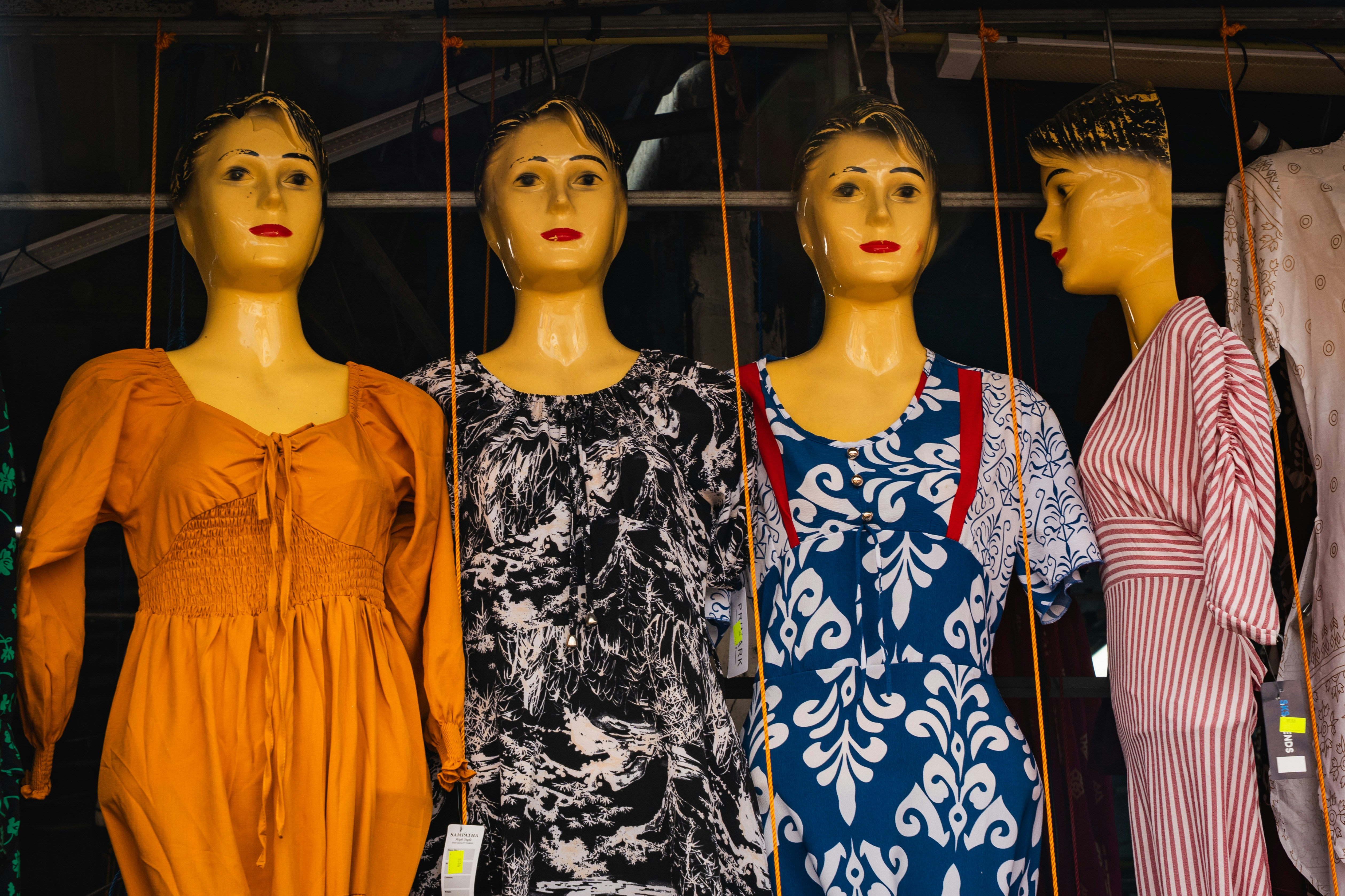 Row of mannequin dresses under staged showroom lights