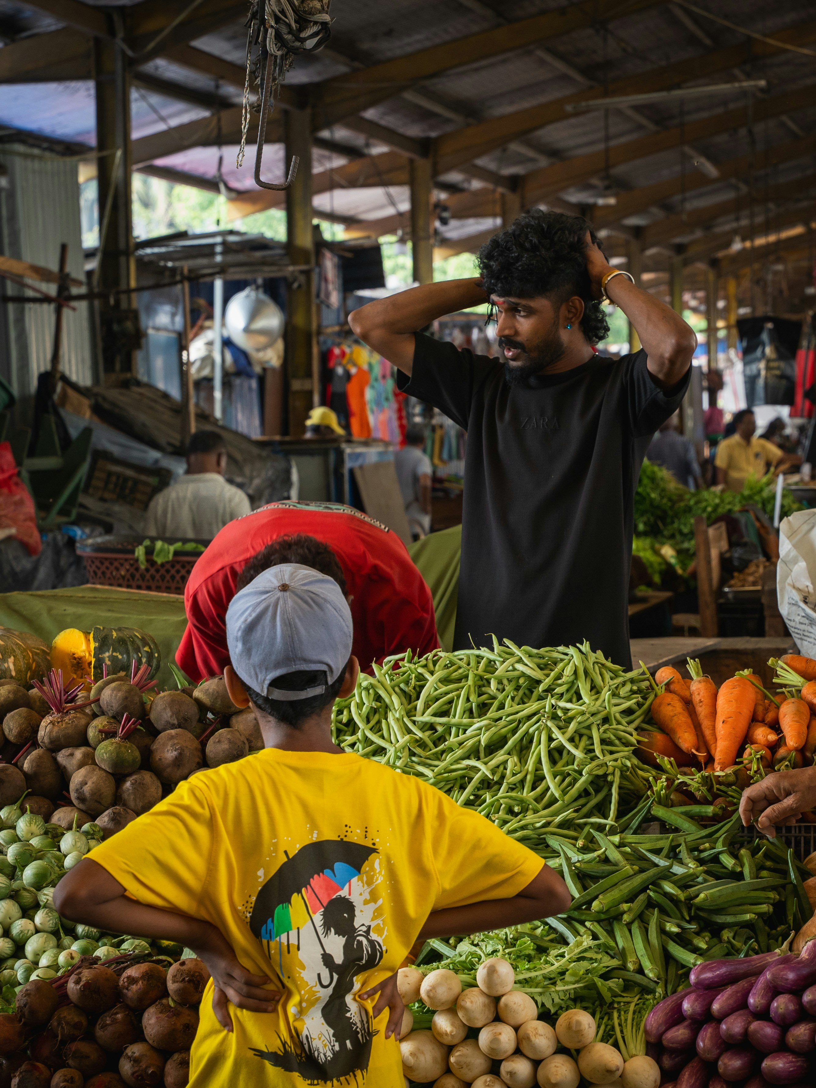 Market Pulse: A Young Vendor and a Thoughtful Stranger Amid Fresh Produce