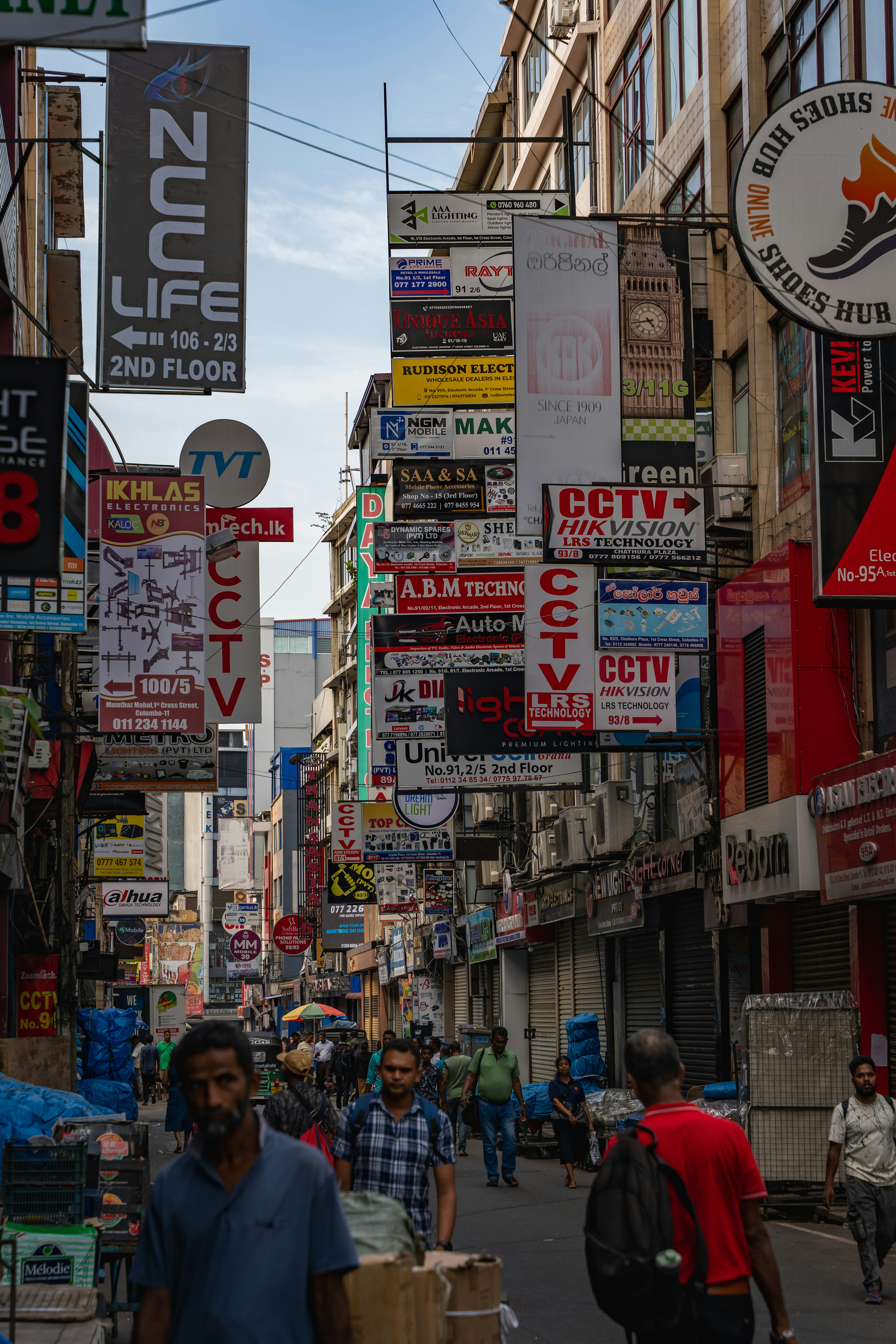 Crowded Neon Canyon: A Street Laden with Signs and Pedestrians