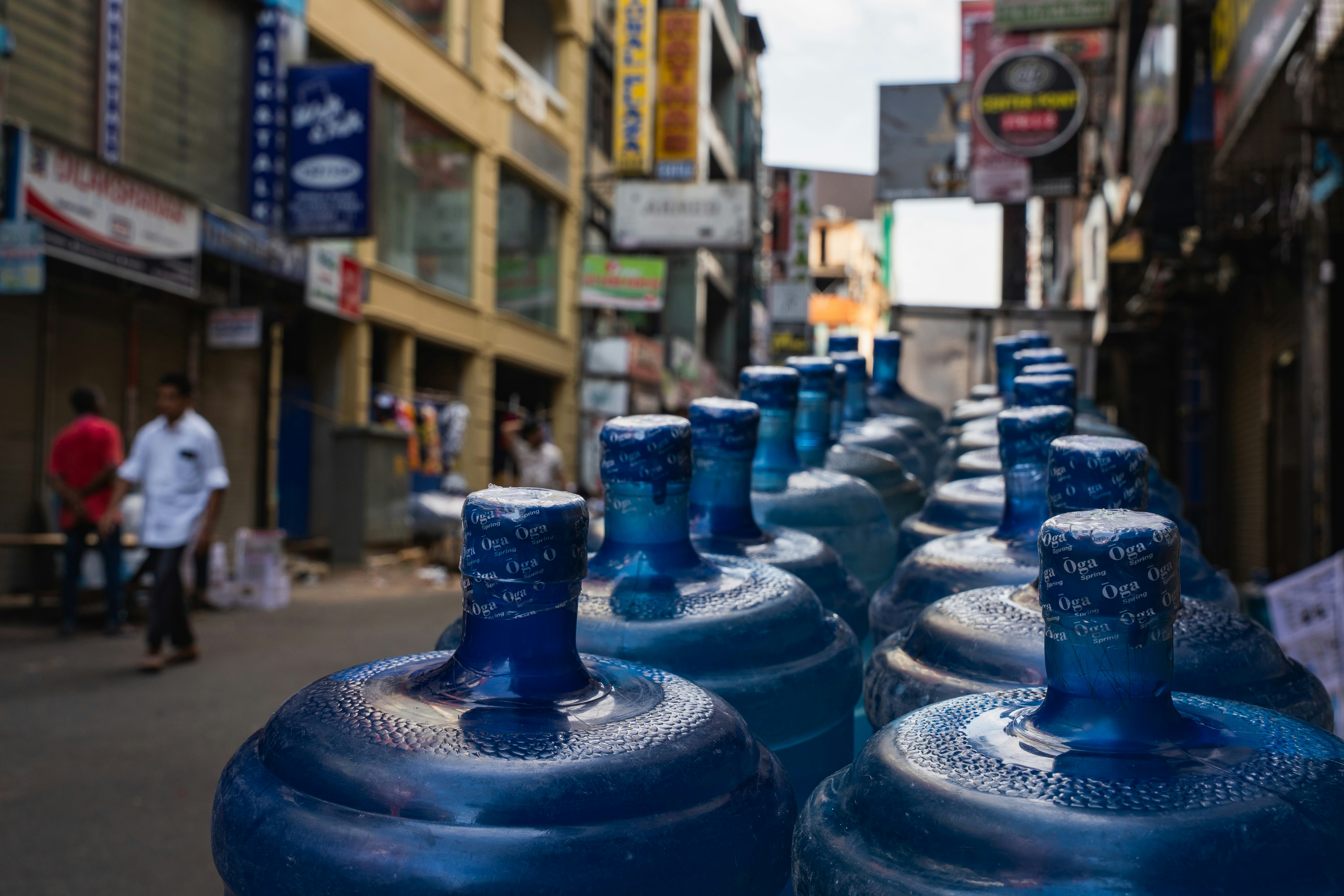 Columns of Blue: A Row of Cooled Bottles marching down a bustling street