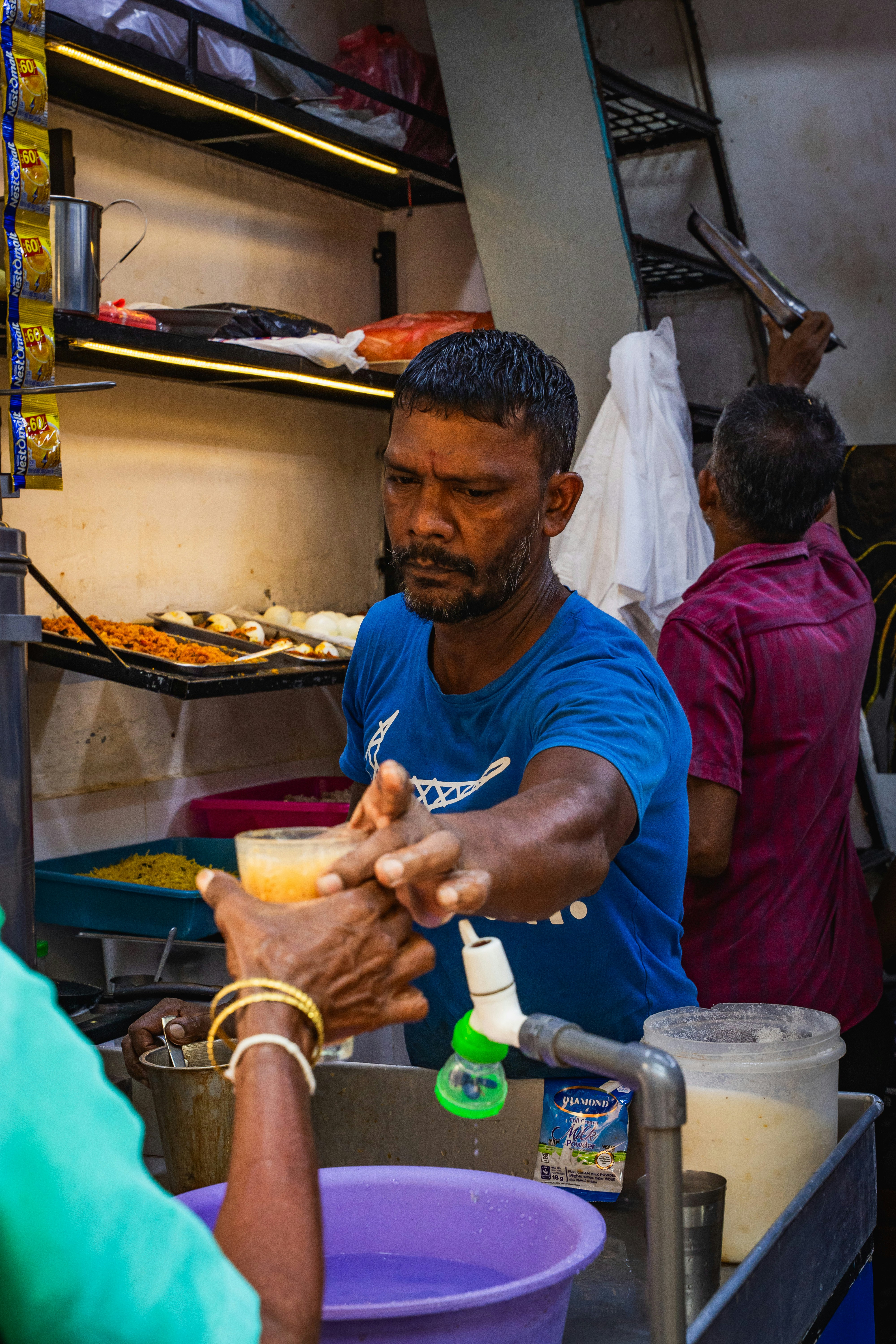 Hands Exchange at a Busy Street Kitchen