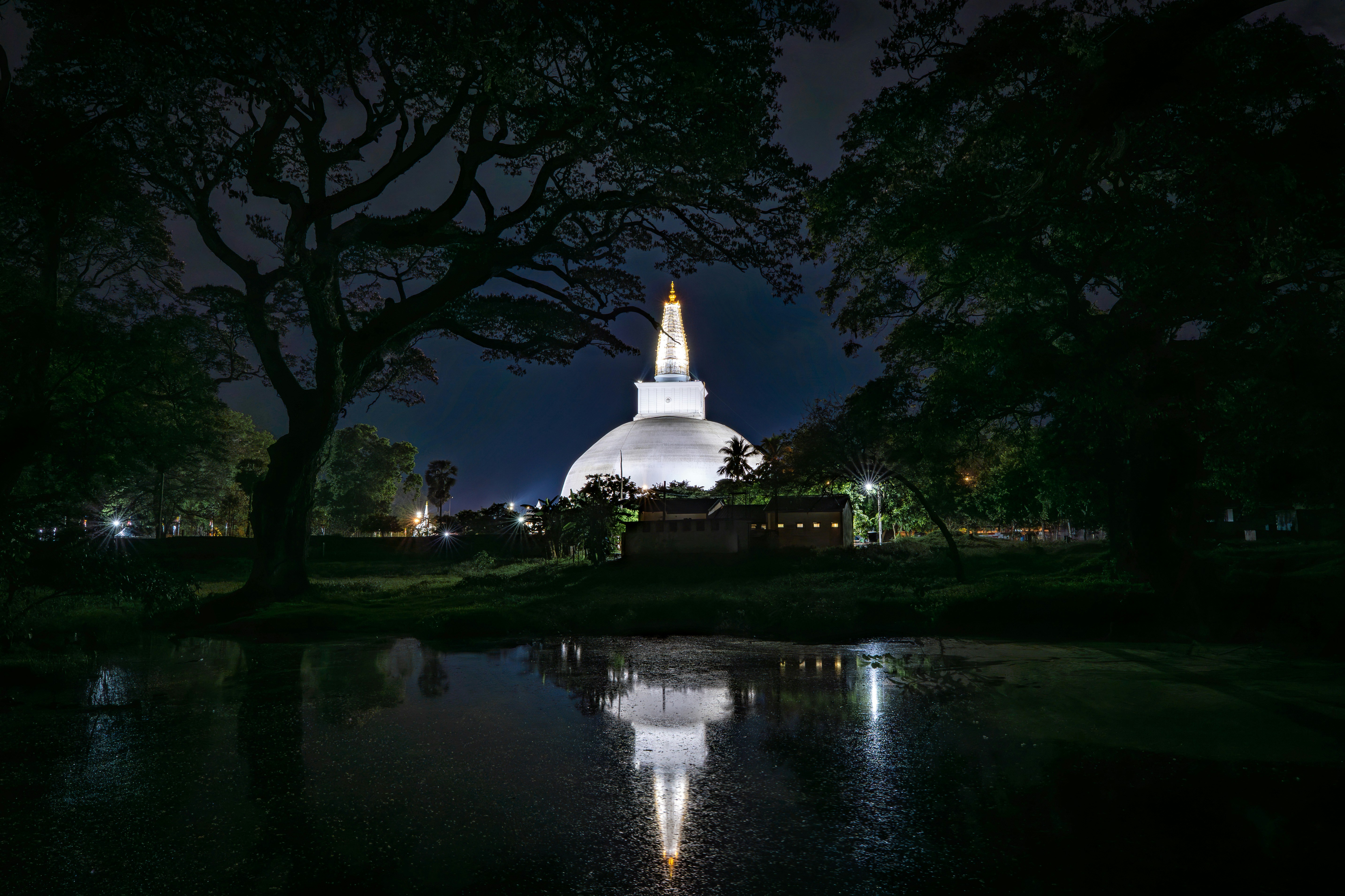 Moonlit Stupa Reflections: Nighttime Serenity by the Lake