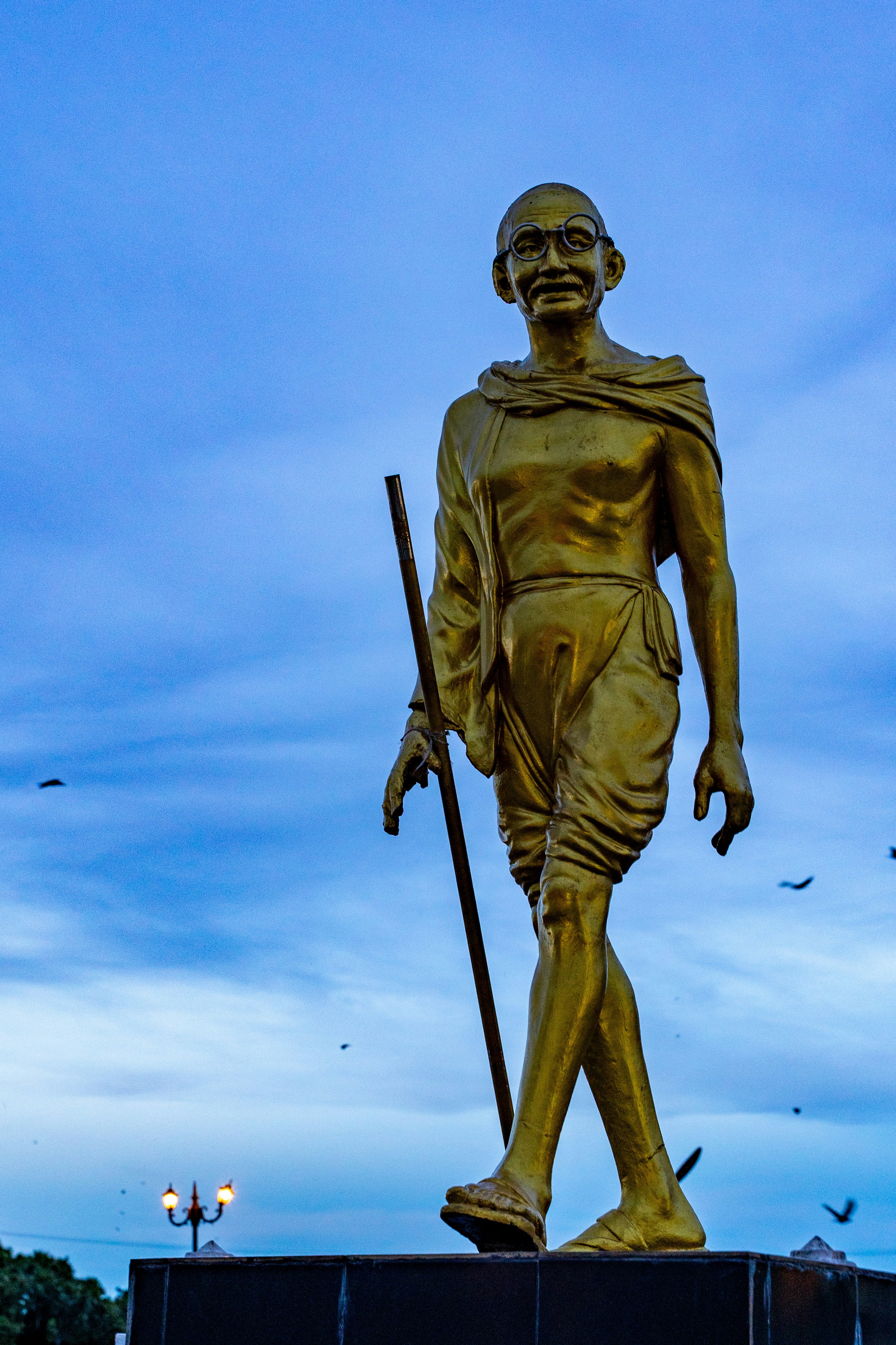 Golden Statue of a Walking Monk Reaching Toward the Sky