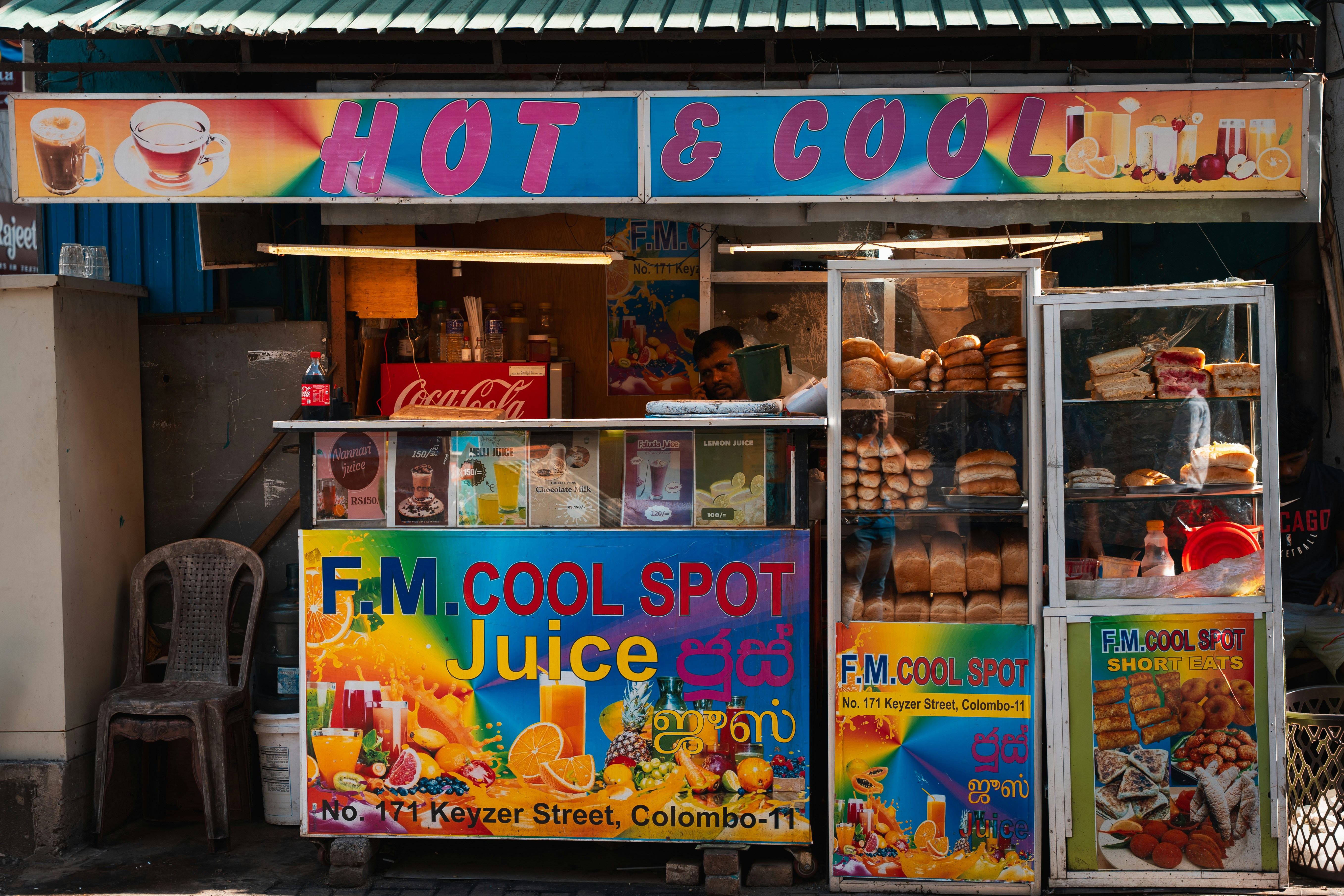 Vibrant street stall offering hot, cool drinks, and snacks.